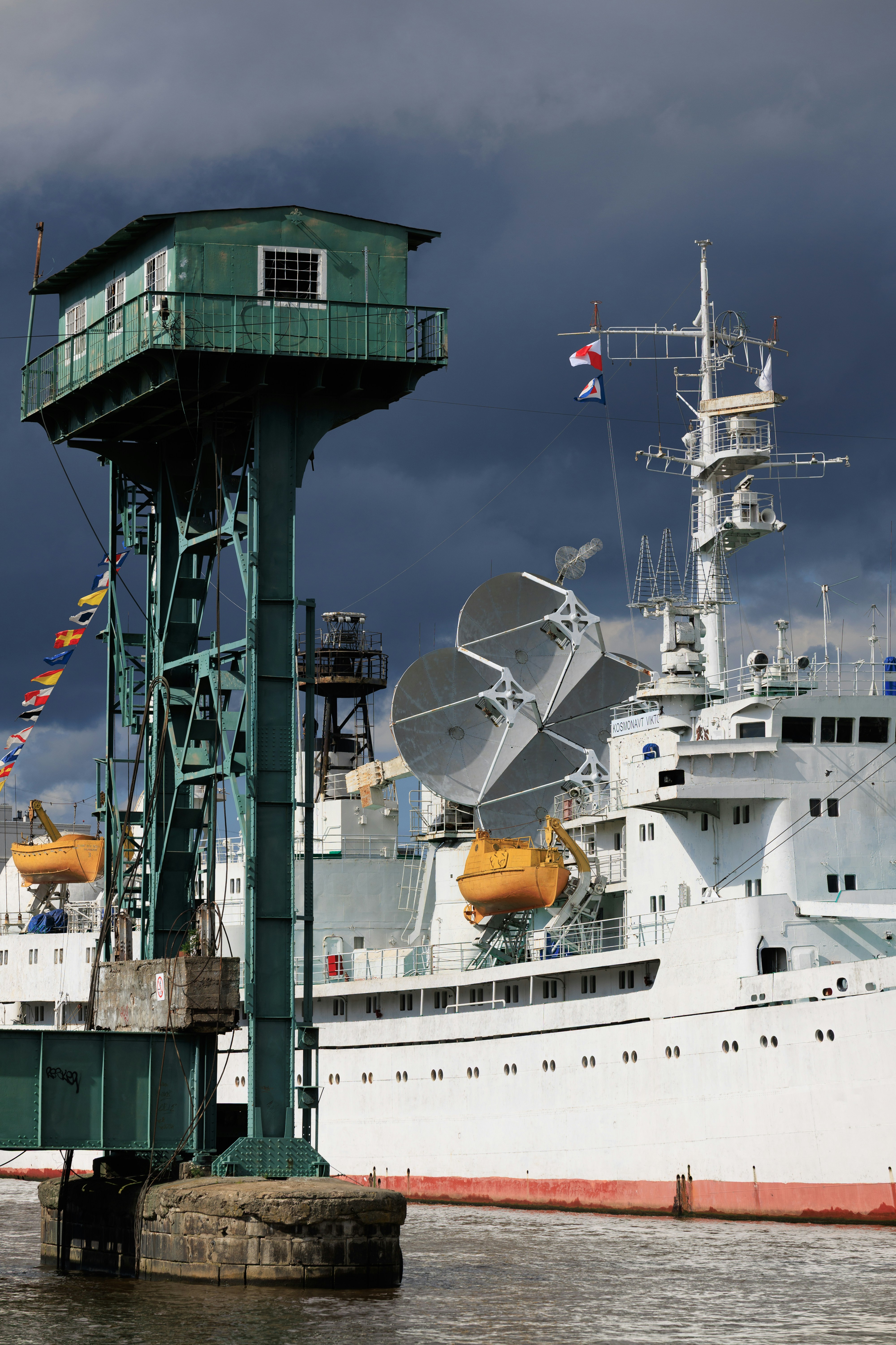 Harbor Sentinel: Green Watchtower Overlooking a White Maritime Vessel