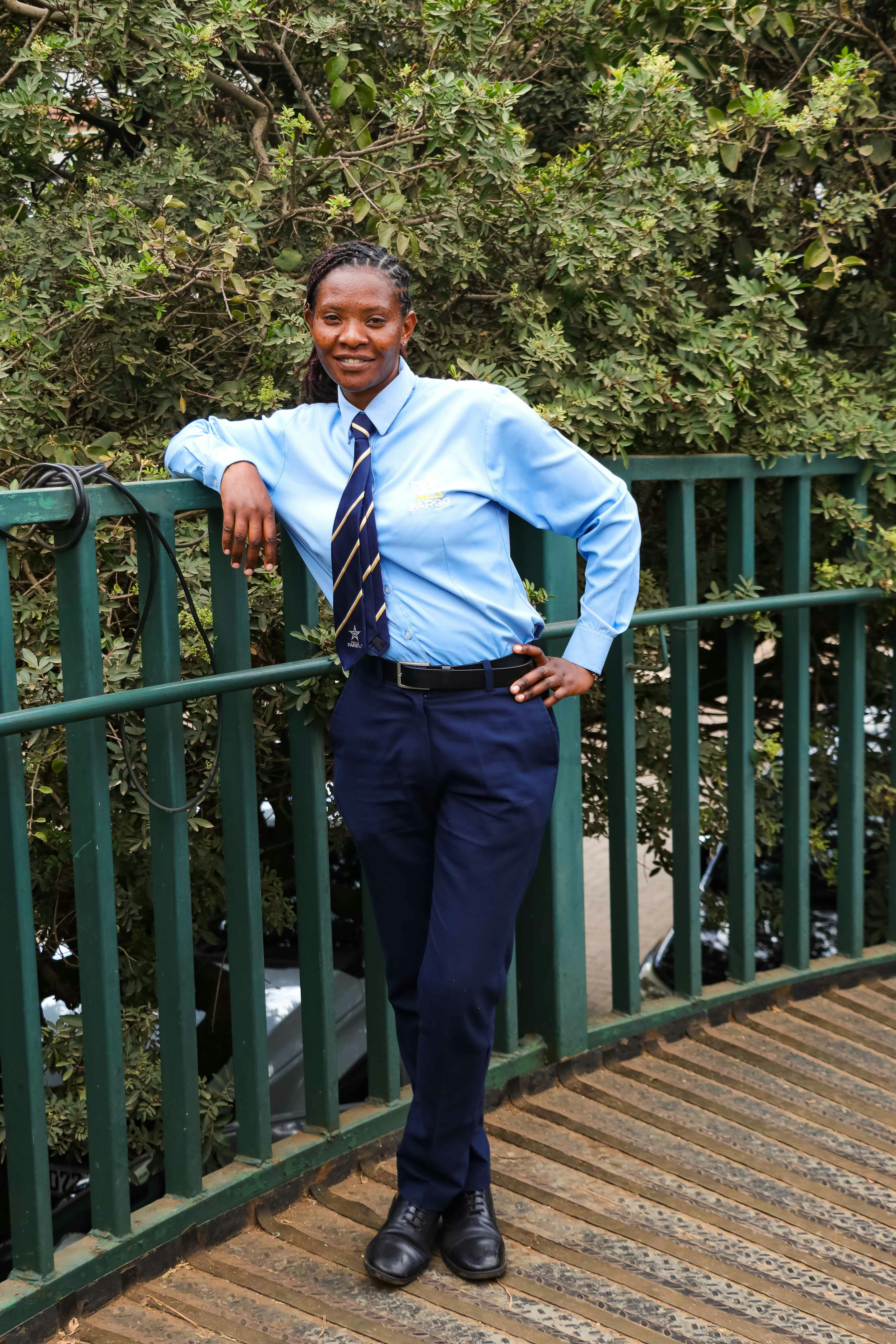 Confident Student in Light-Blue Uniform Leaning on a Green Railing
