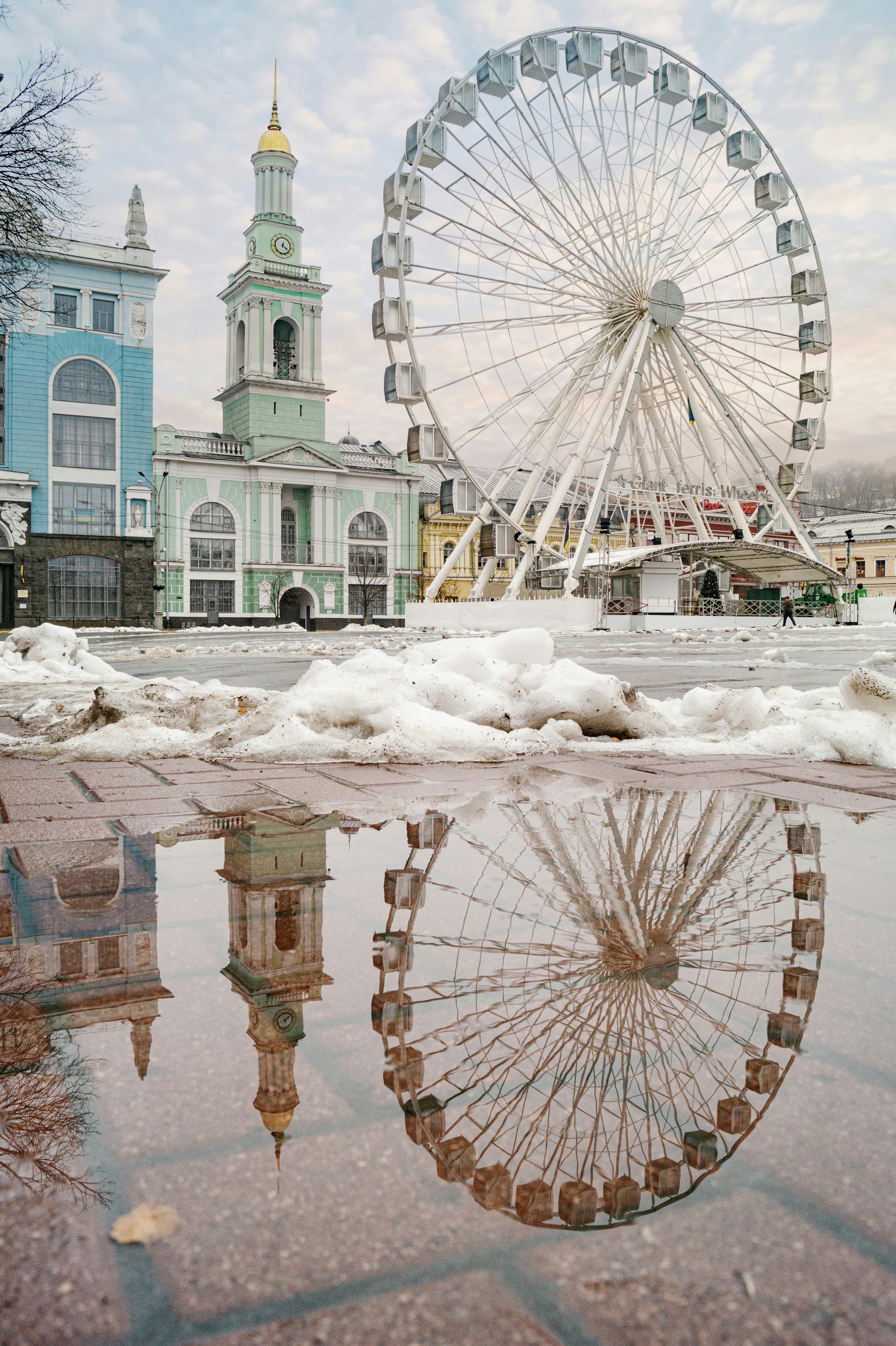 Circular Giant: A Snowy Townsquare Reflected in Glass