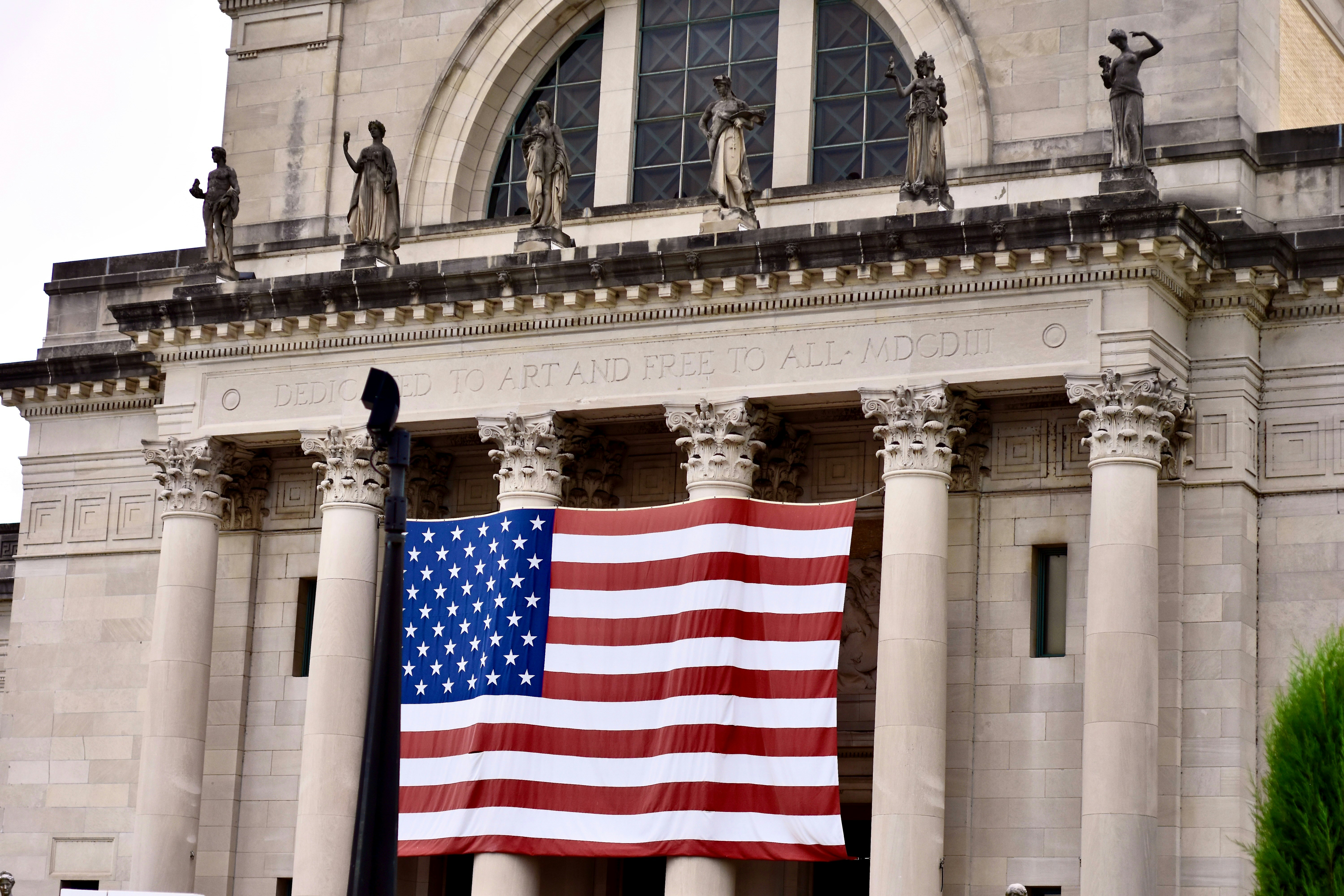 Patriotic Flag Draped Over Classical Facade of a Civic Building