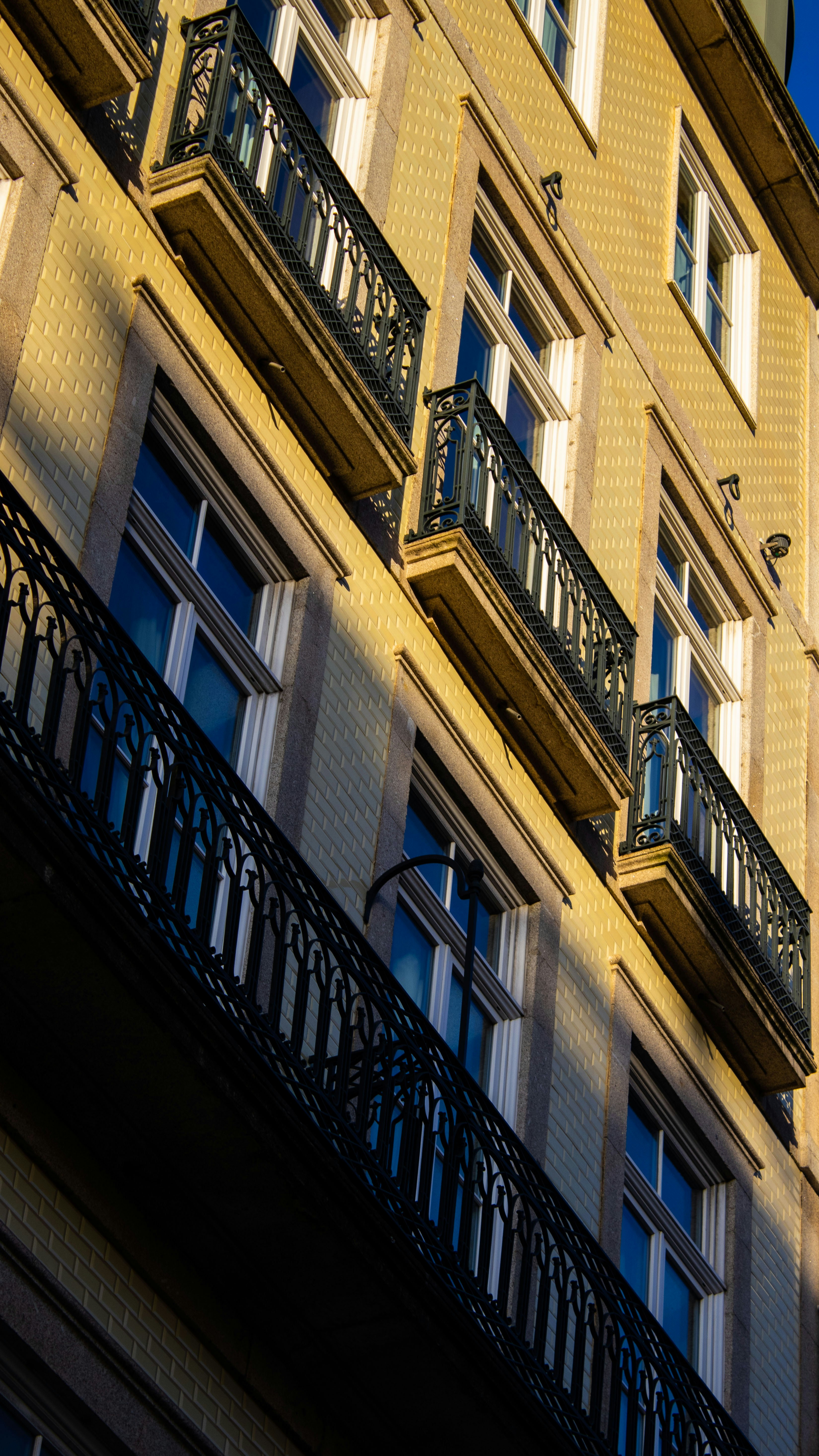 Sunlit Facade: Geometric Rhythm of Balconies on a Vintage Building