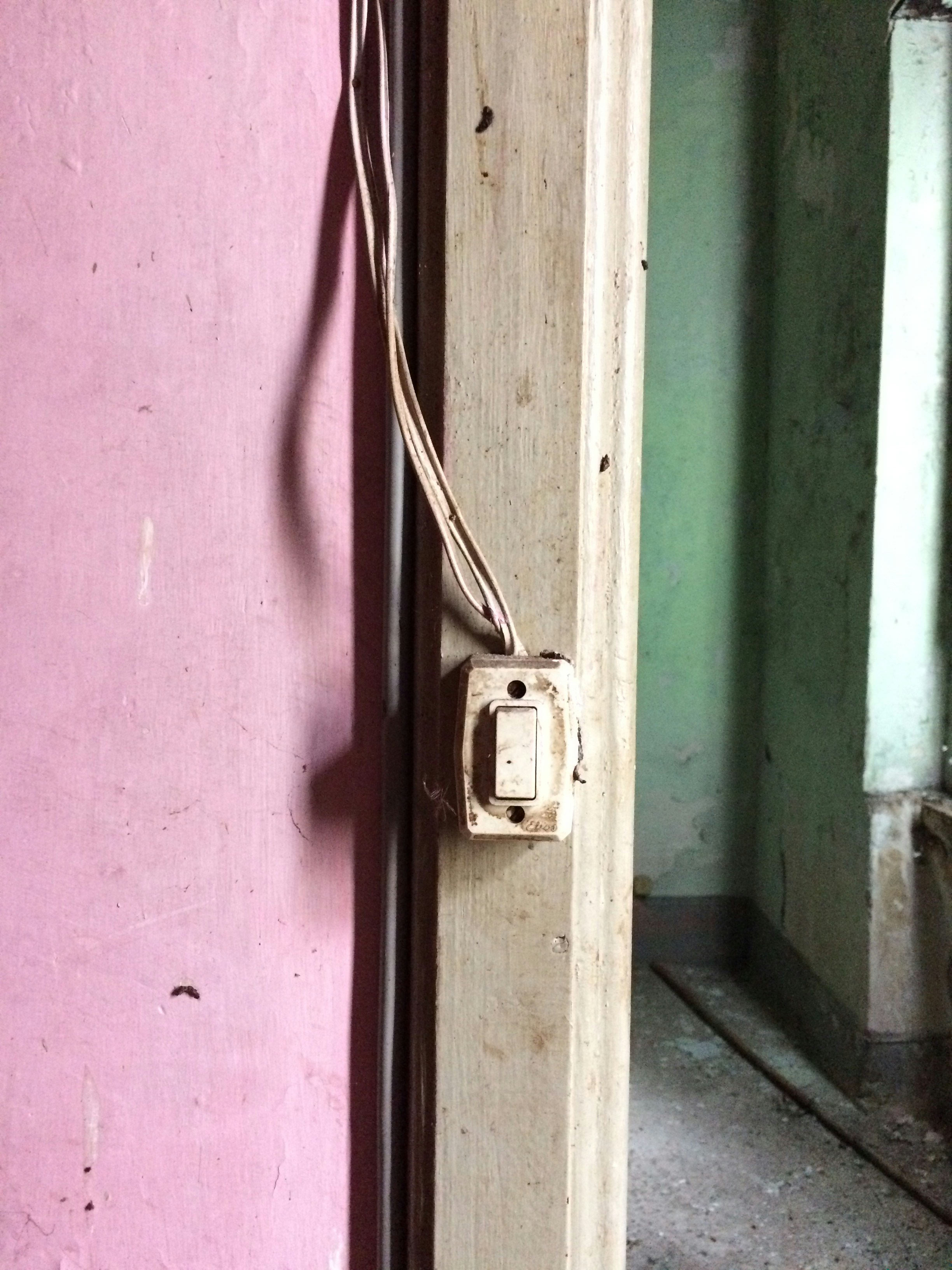 Doorway to Echoes: A Pink Wall and Worn Switch