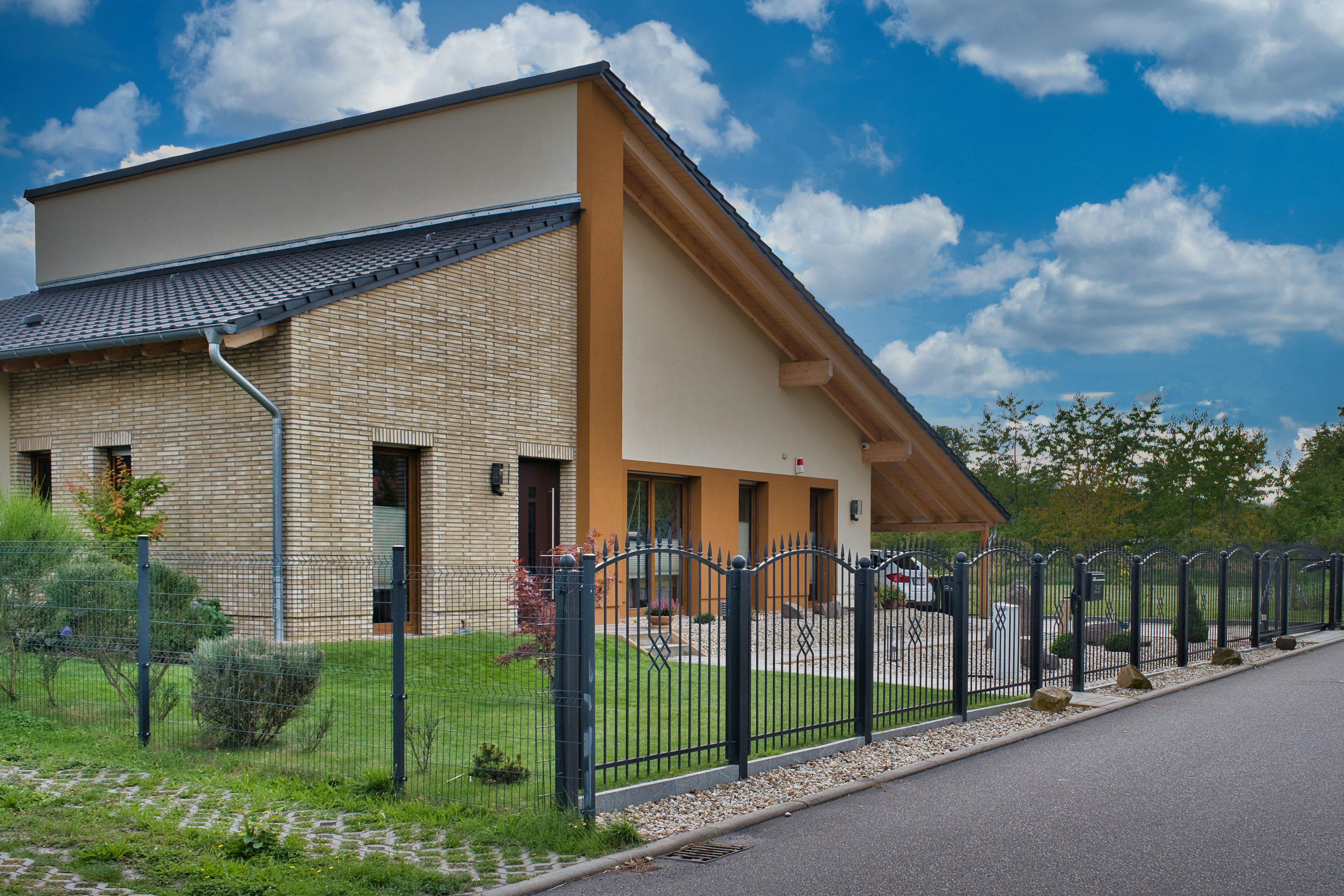 Sunlit Modern Pavilion Beside a Fenced Drive