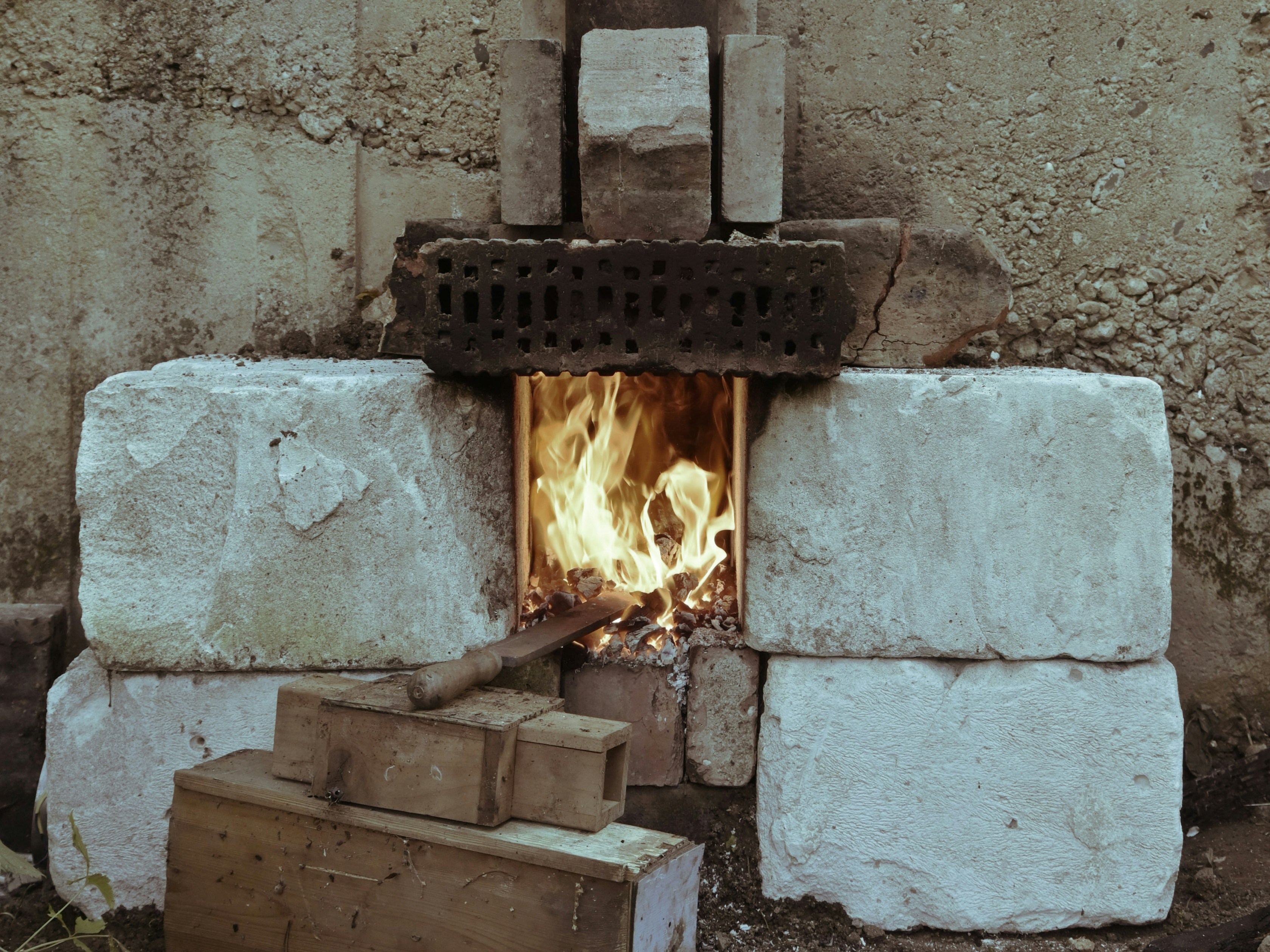 Primitive kiln: fire-lit furnace built from concrete blocks