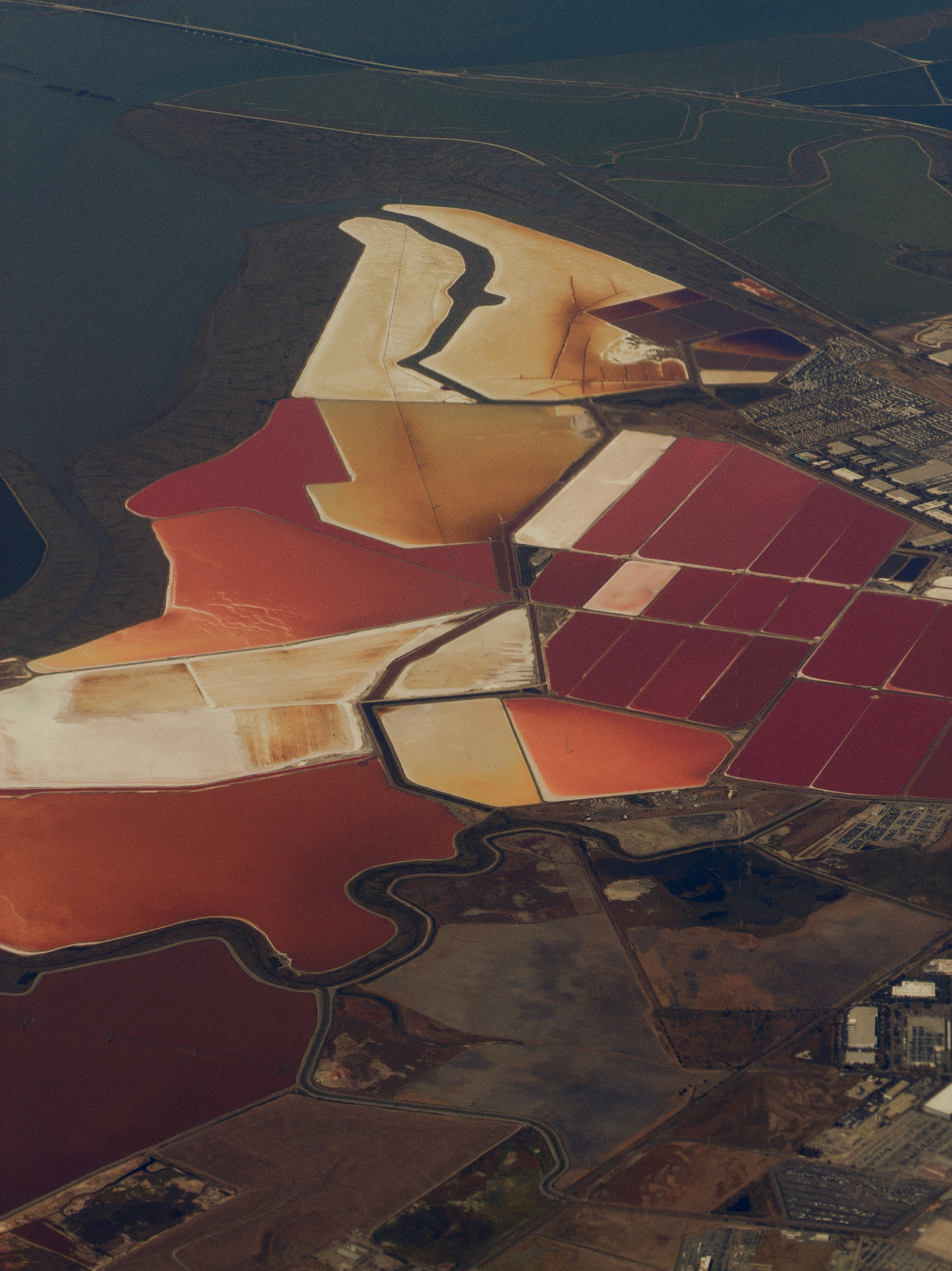 Crimson Salt Fields: A Patchwork of Earth Tones from Above