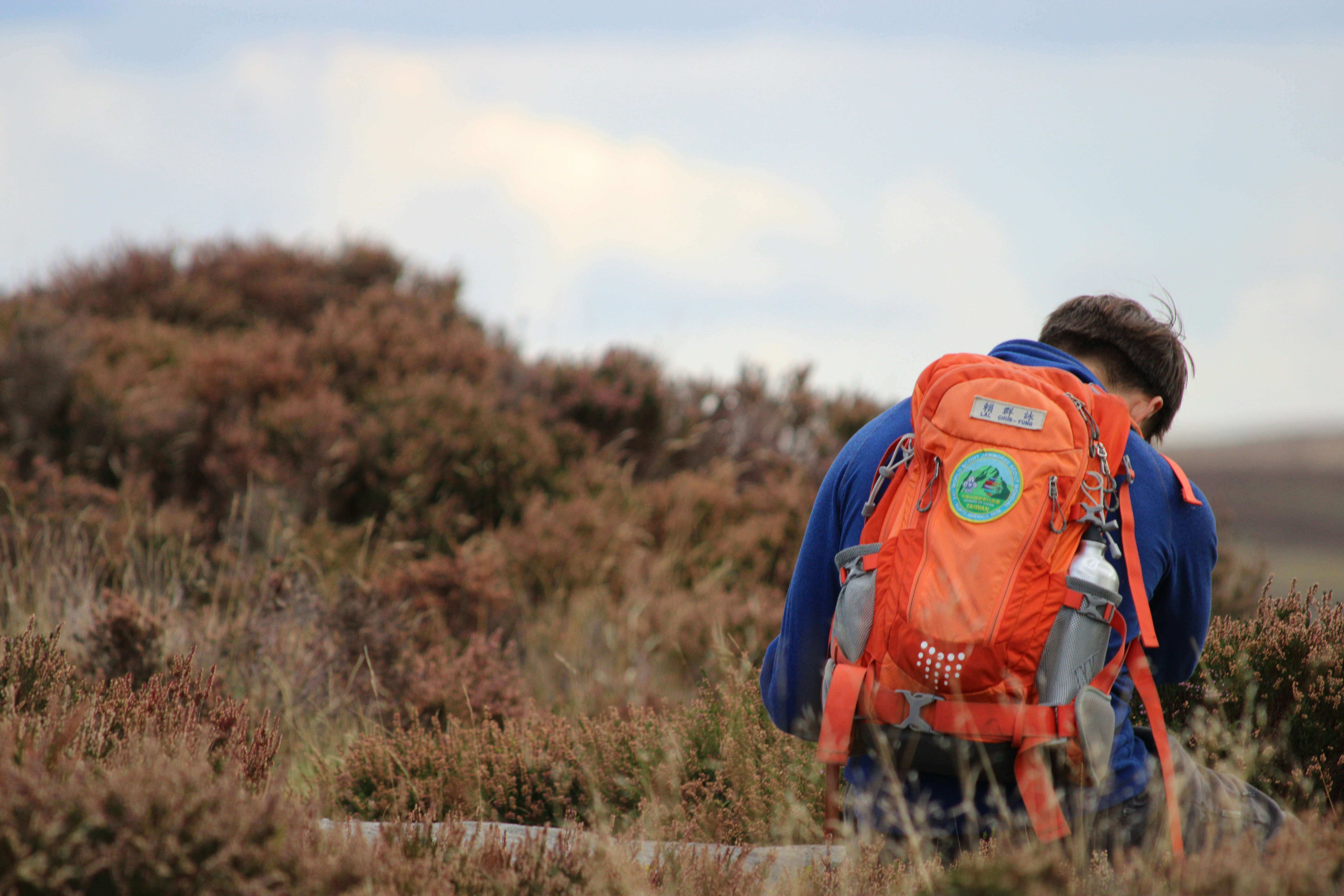 Backpack Trek: a lone hiker presses through windswept heath