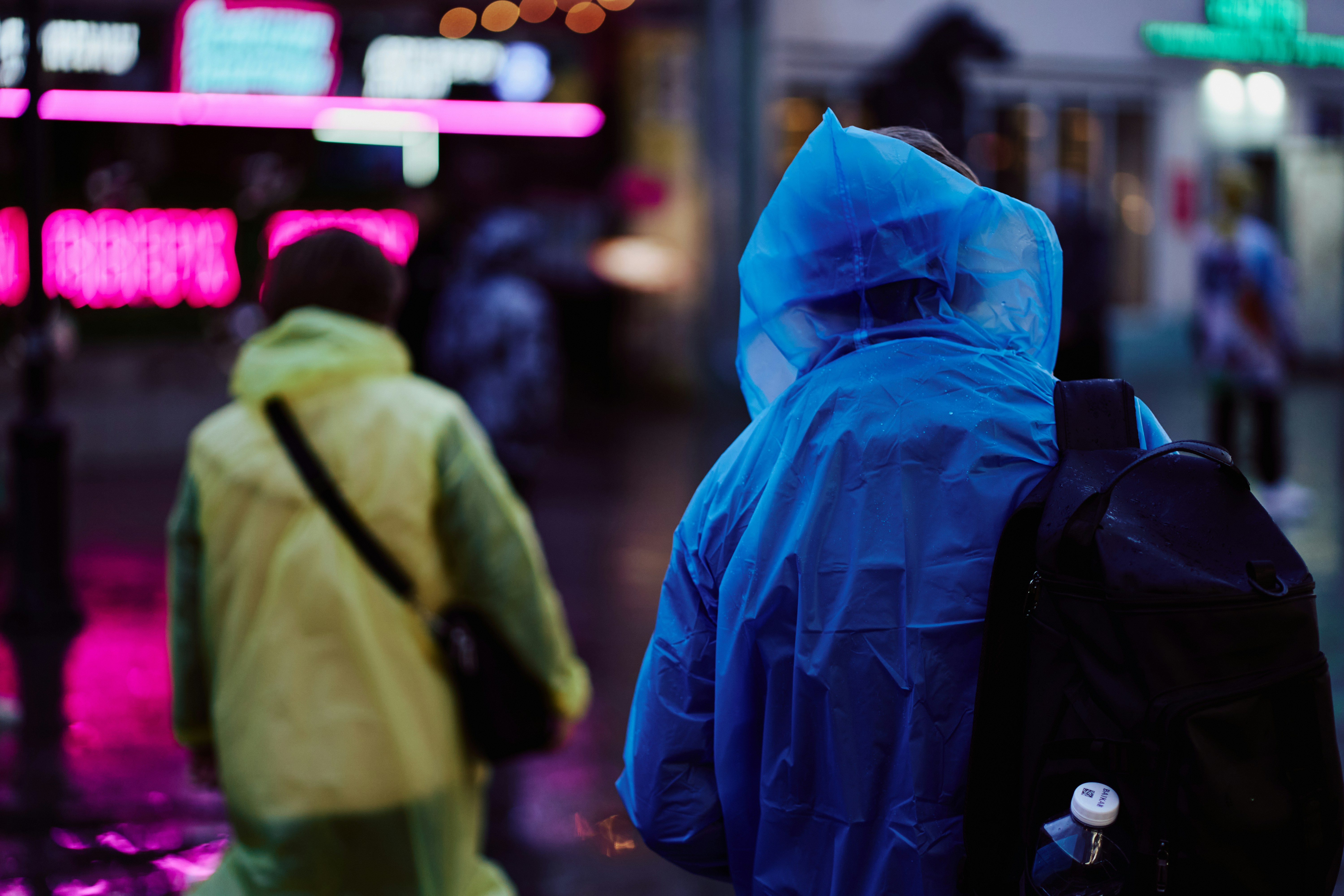 Blue Hood in Neon Rain: A City Night Portrait