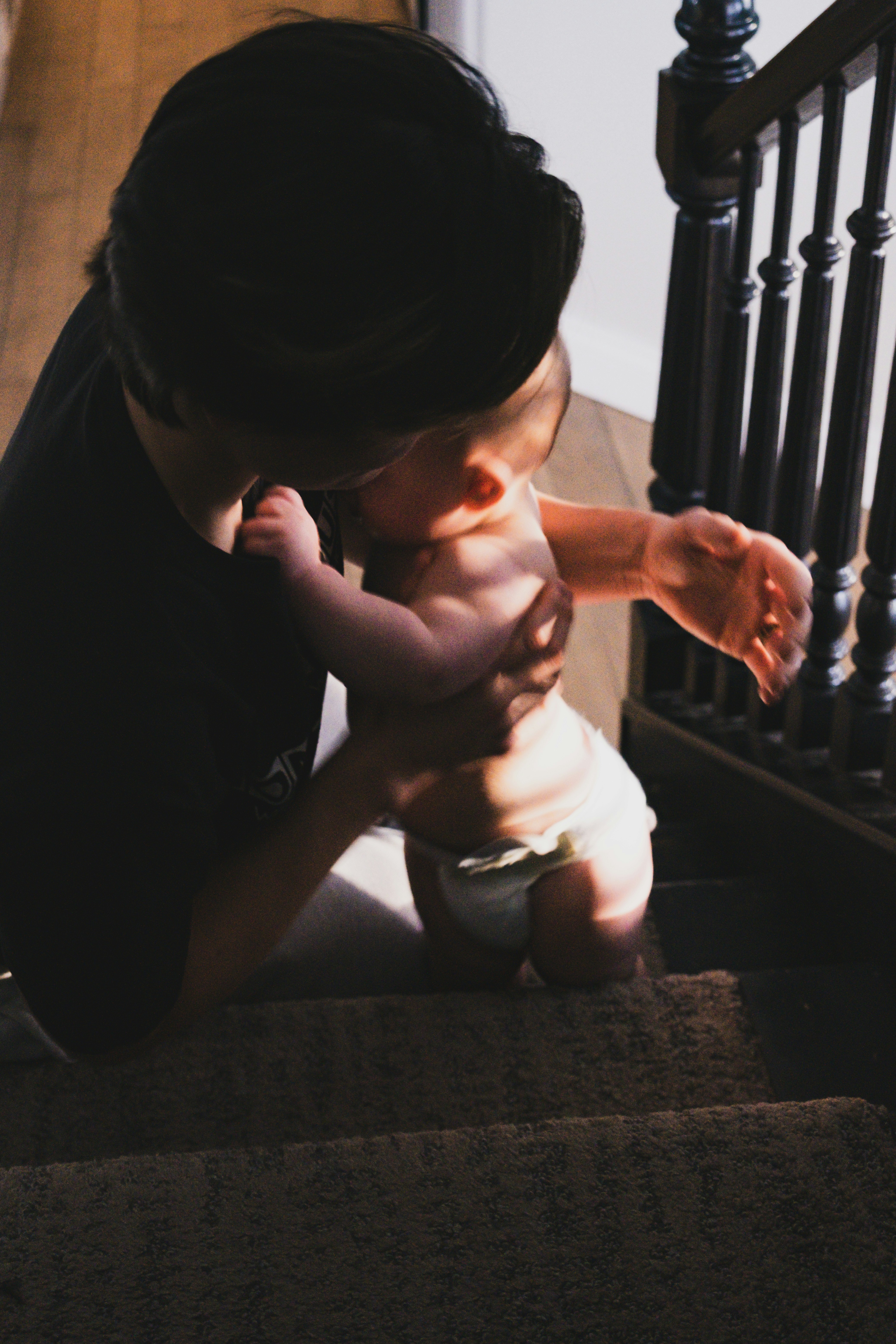Mother and Child on a Staircase: Tender Moment in Shadowed Light