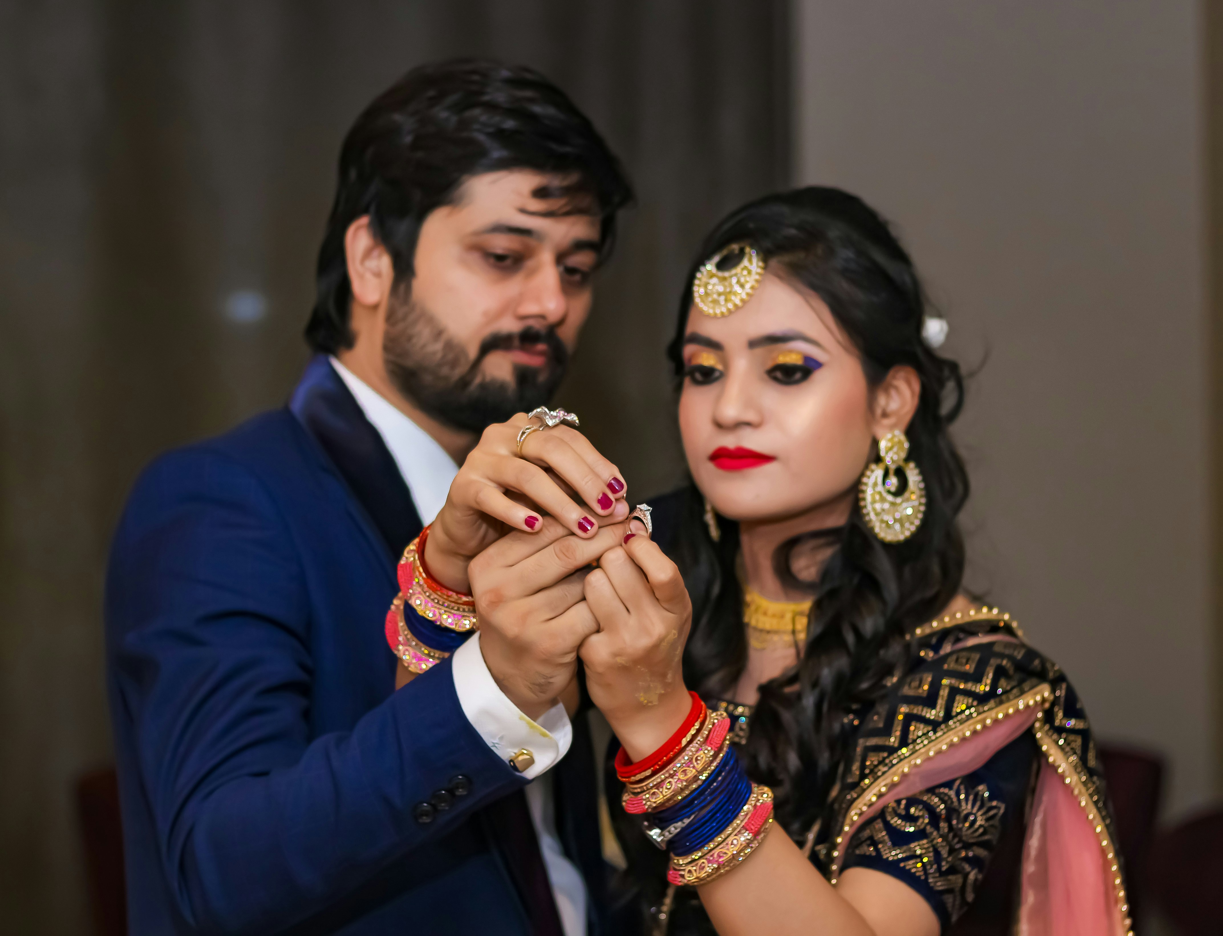 Two Intricate Hands: A Bride and Groom Exchange Symbols of Union
