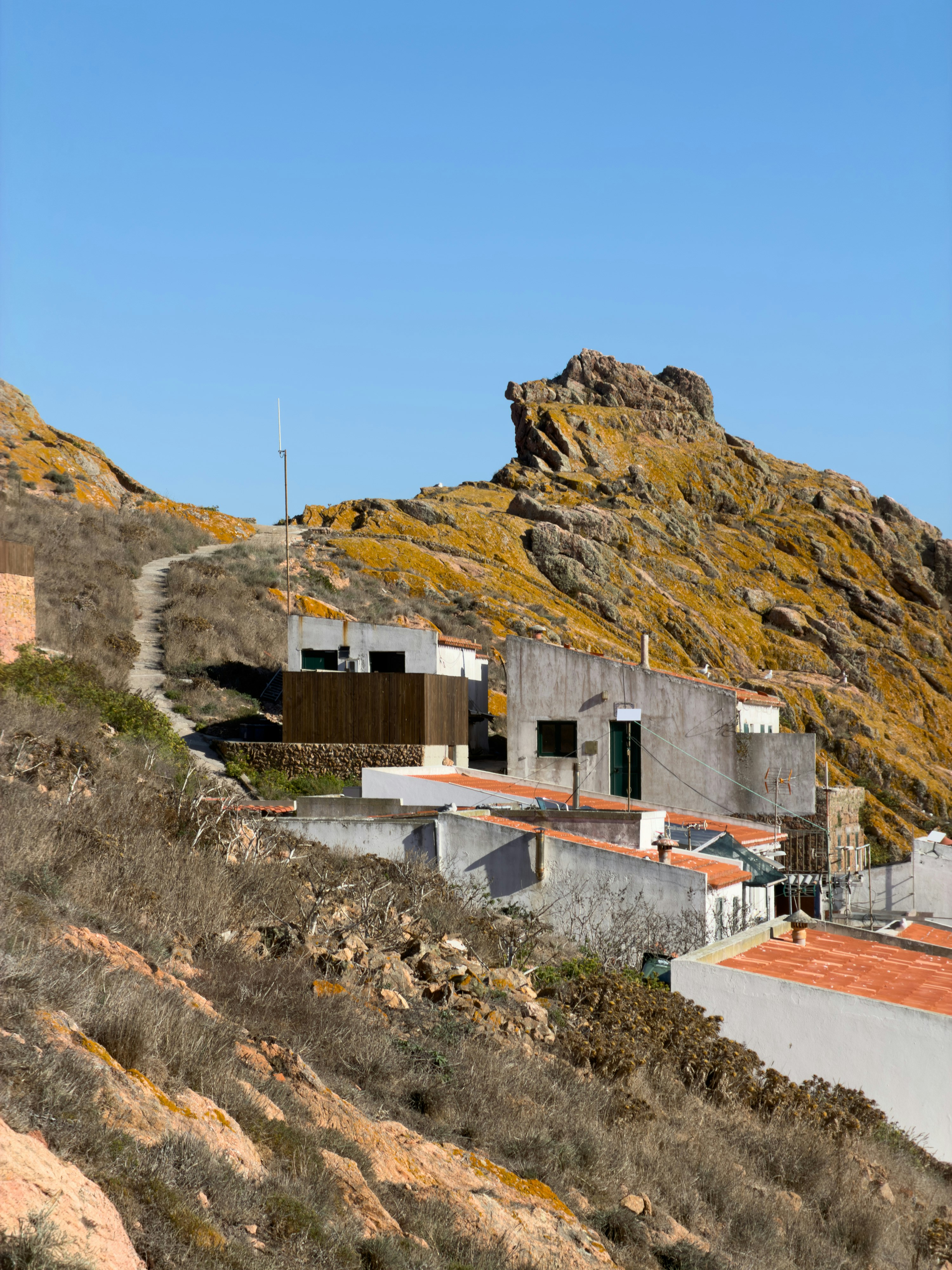 Coastal village on sunlit basalt cliffs