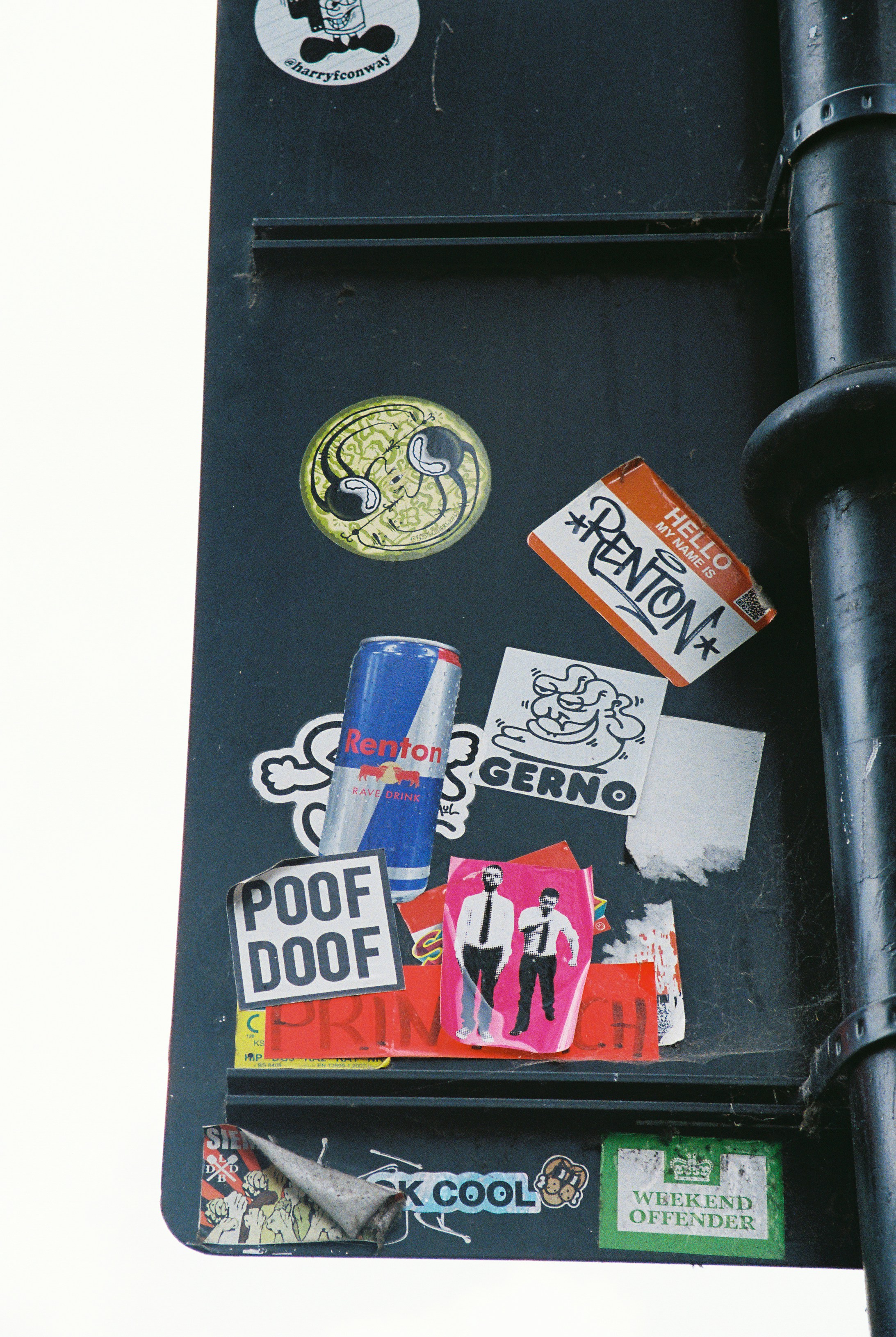 Stickered metal box with colorful brand decals and a glossy mascot badge
