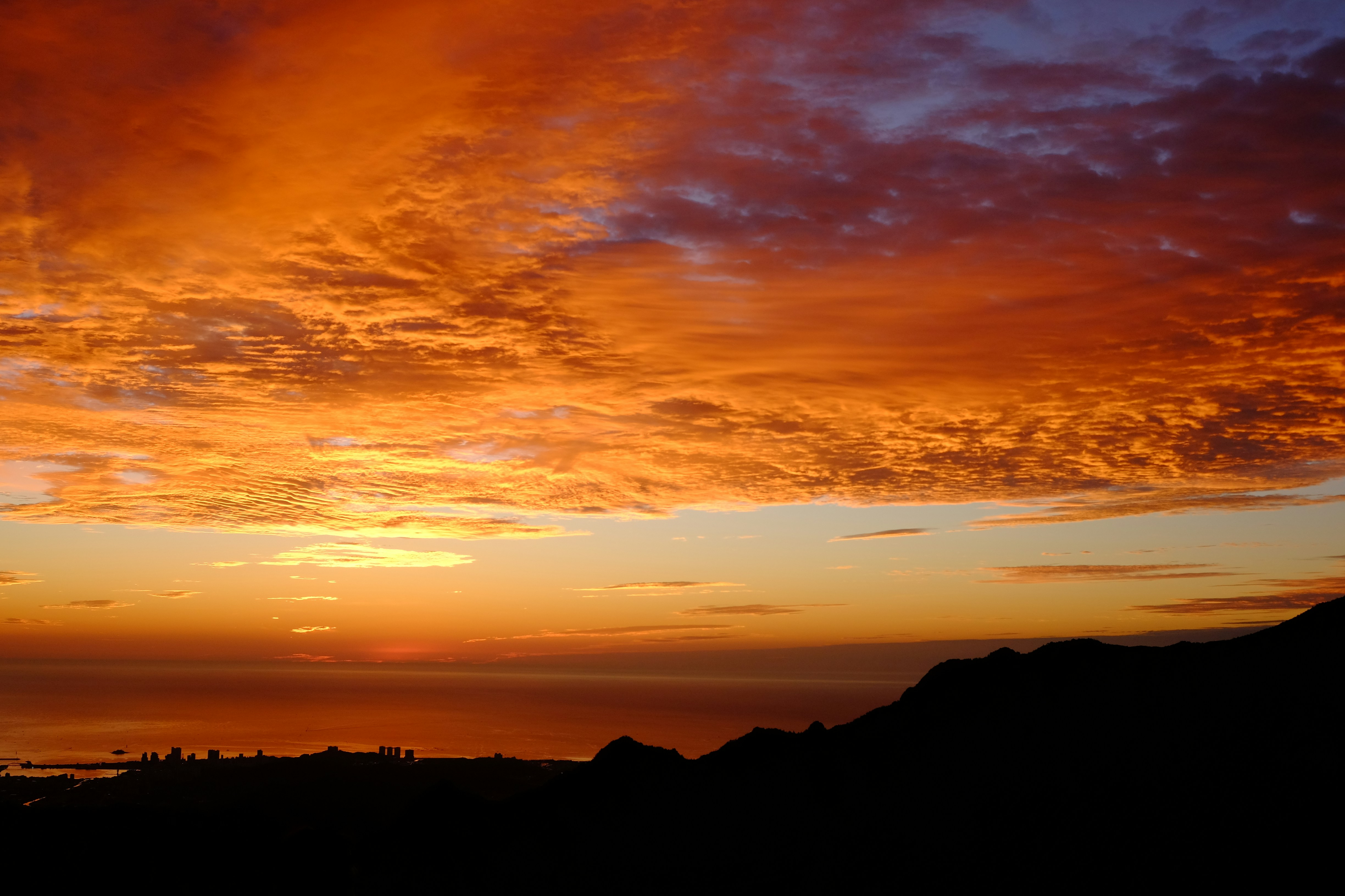 Dusk Over the Ridge: Fire-Tinted Clouds Meet a Silhouette Horizon