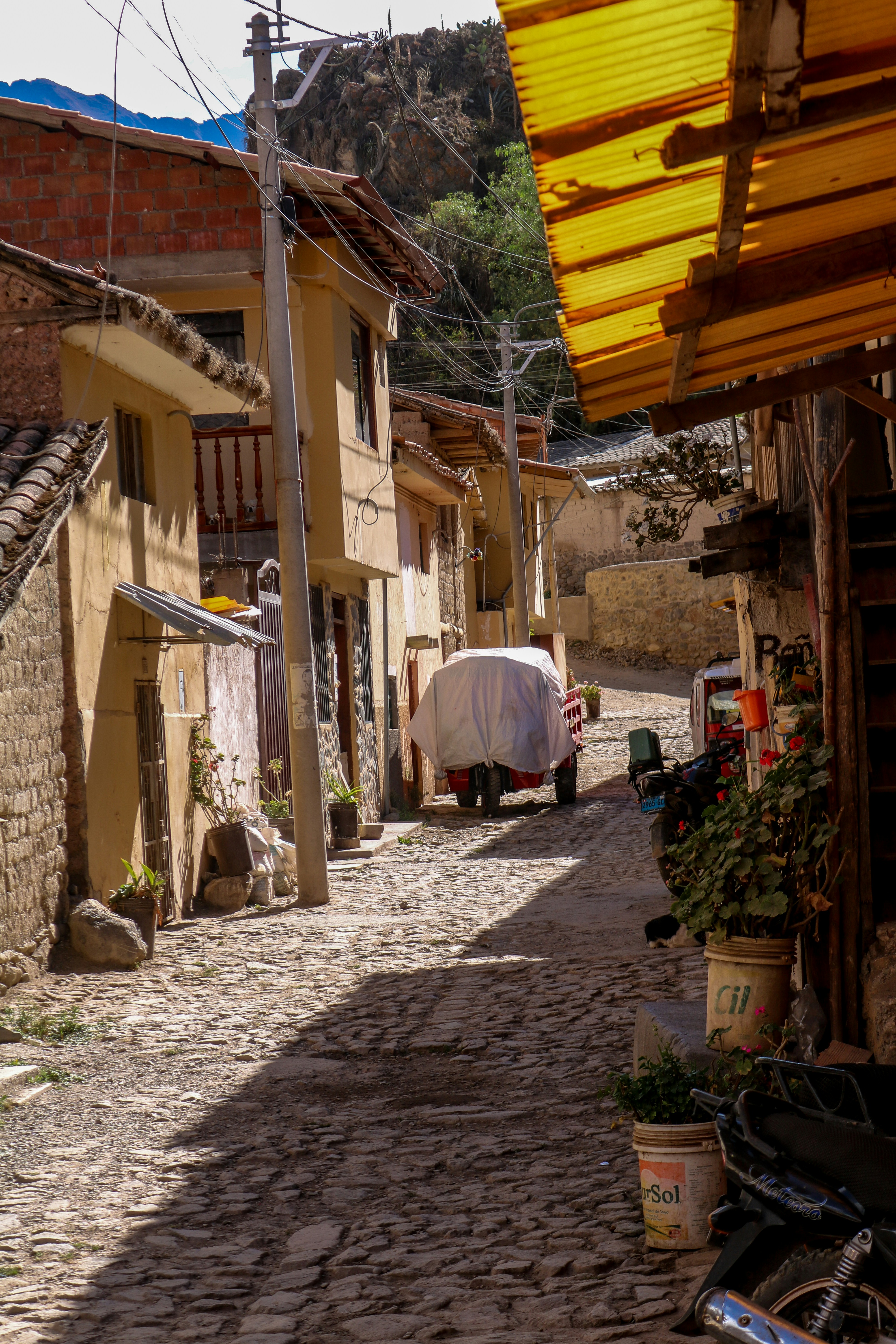 Sunlit Cobbled Alley: a Quiet Corridor Between Tin Roofs and Sunlit Walls