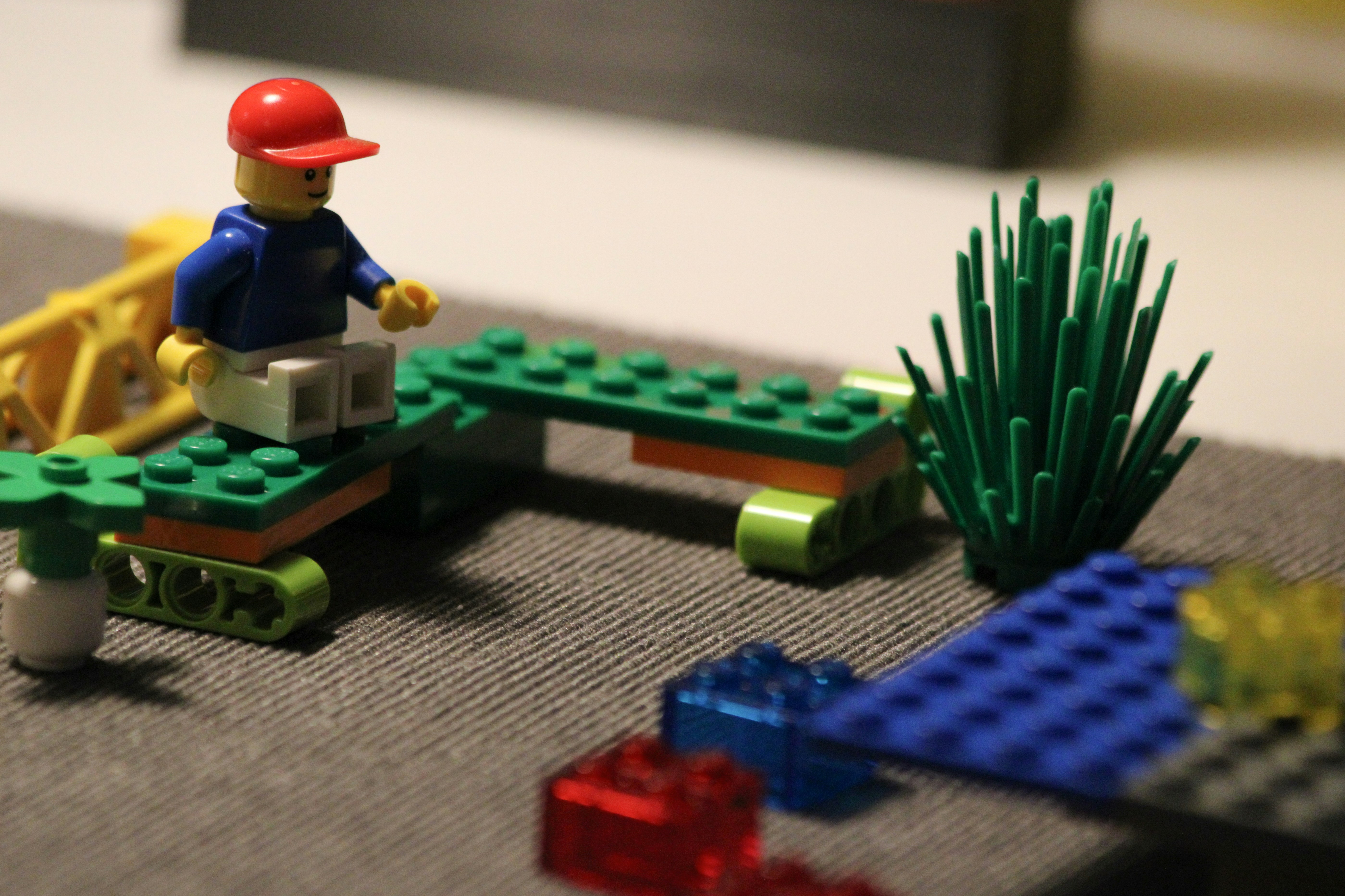 Lego Worker on a Green Platform by a Tiny Pond