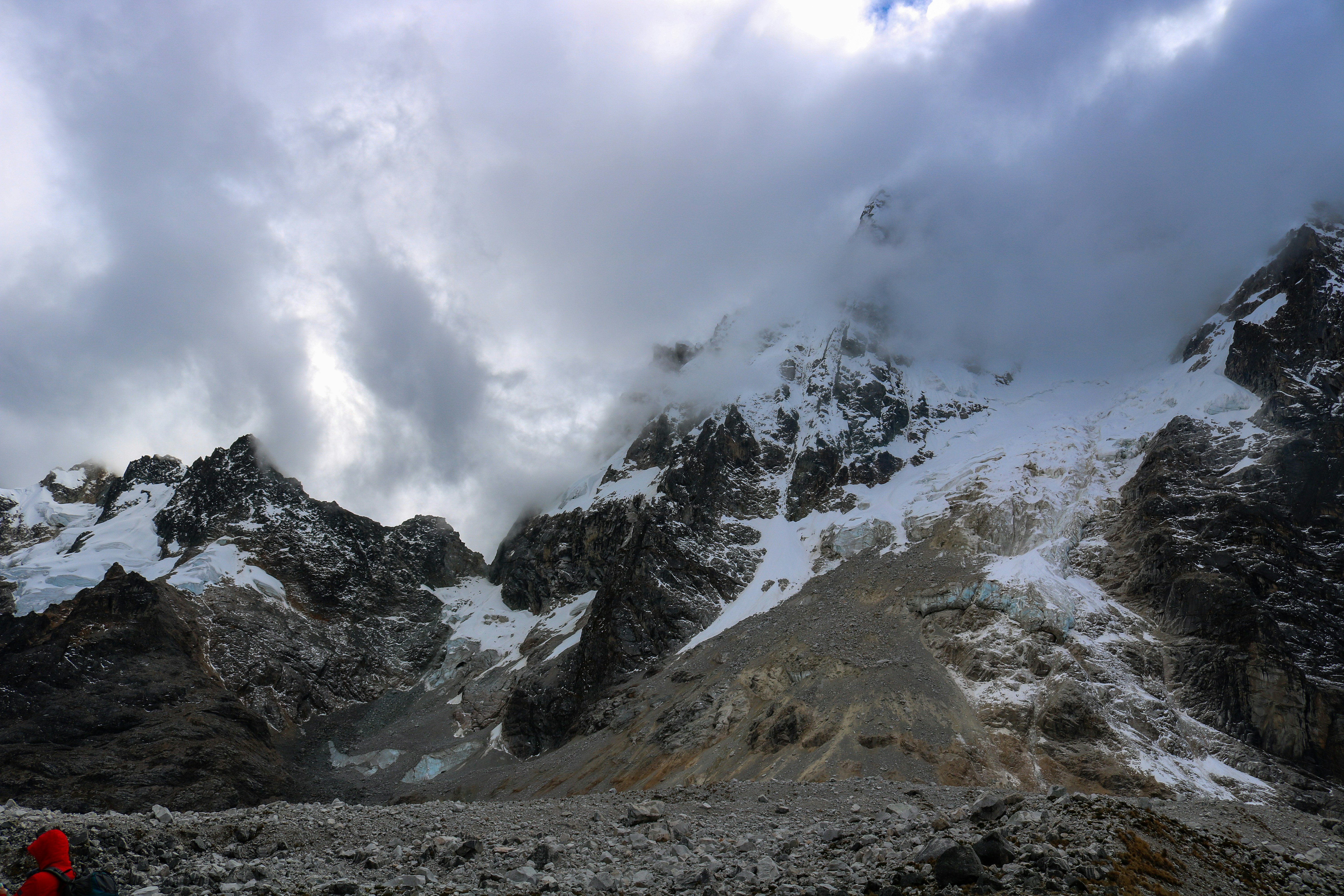 Snow Crowned Peaks Beneath Clouded Sky with Trekker at Foreground