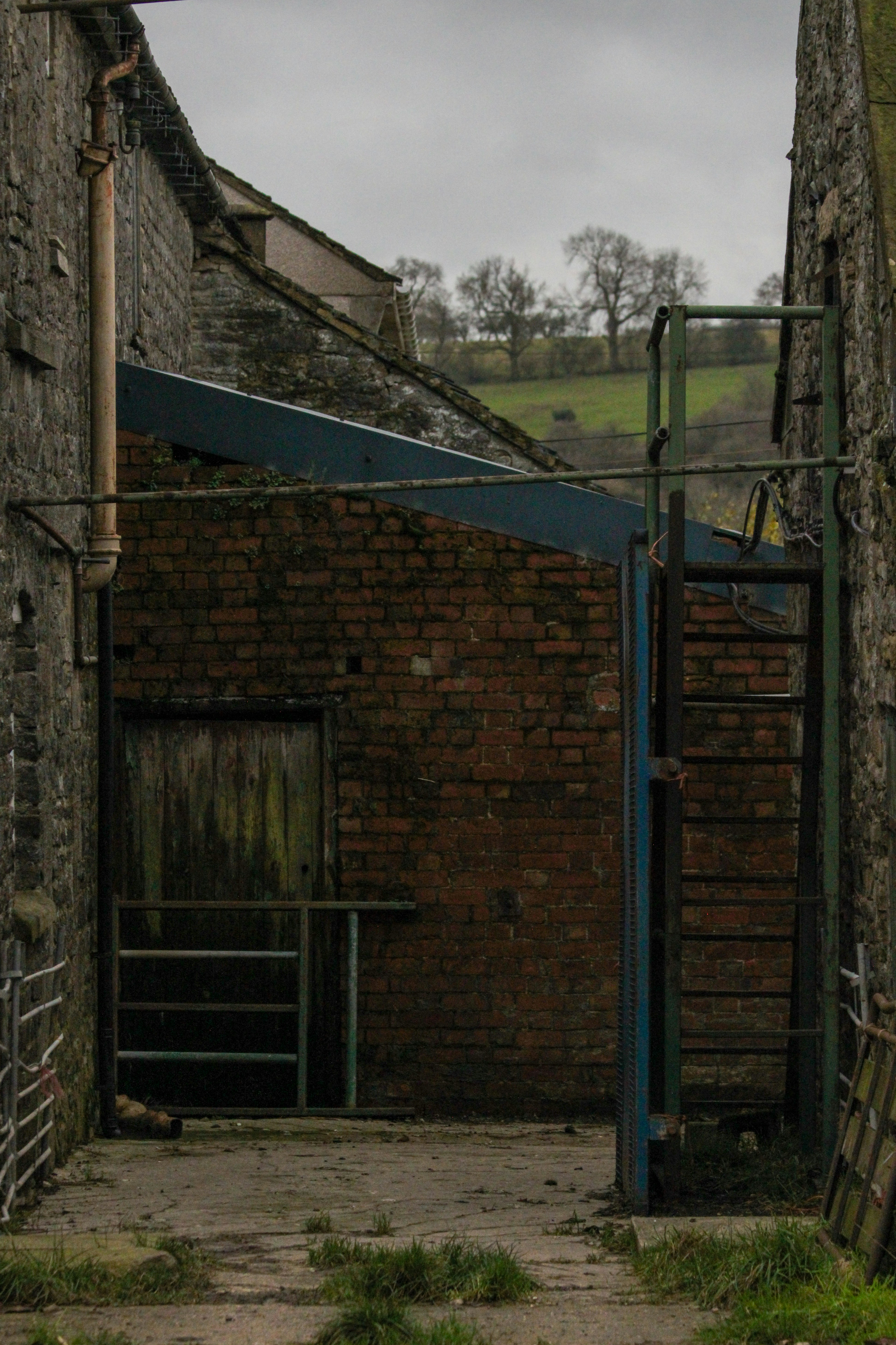Rugged Farmyard Corridor with Weathered Brick and Metal Framework