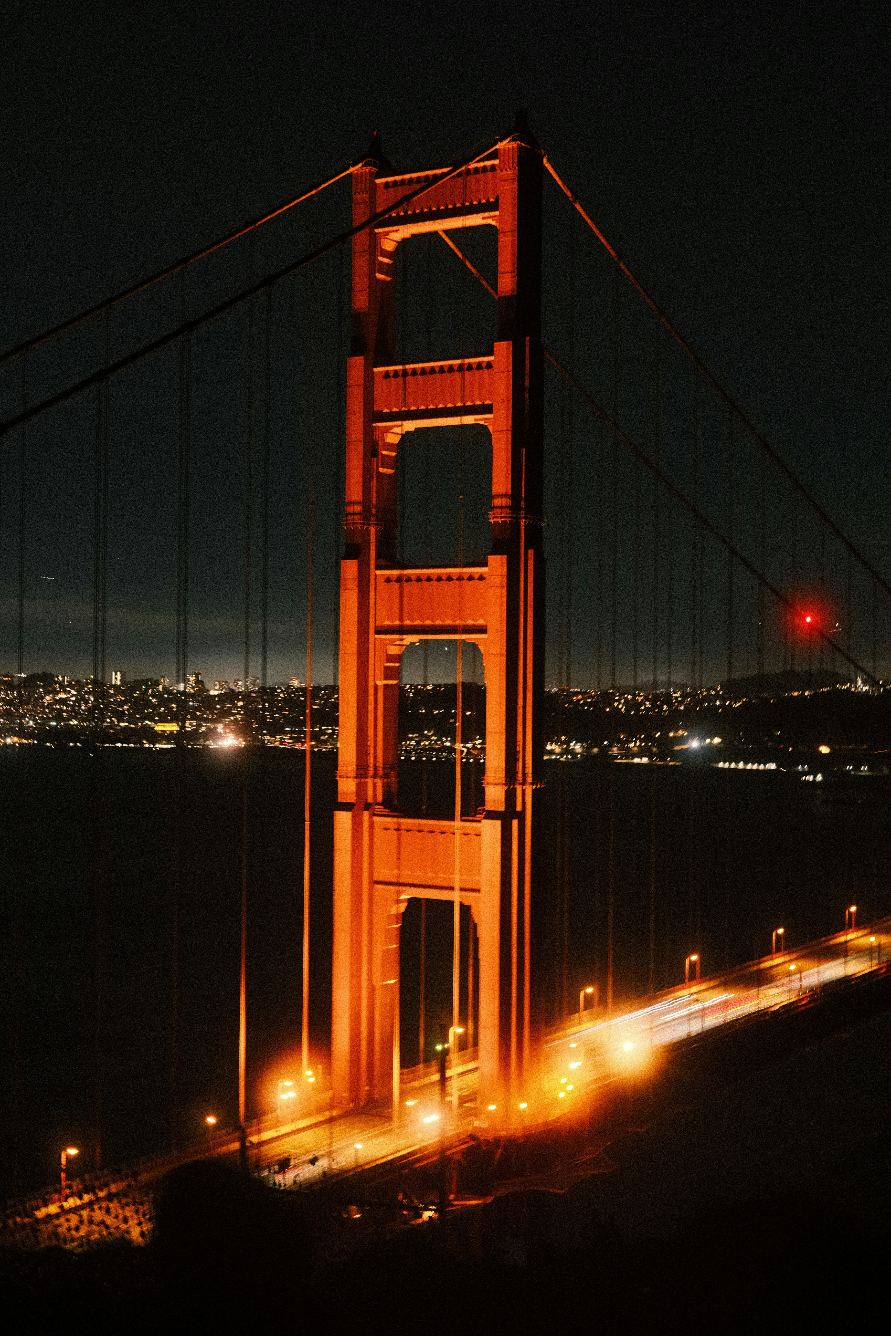 Golden Gate at Night: Steel Monolith Lamed in City Glow