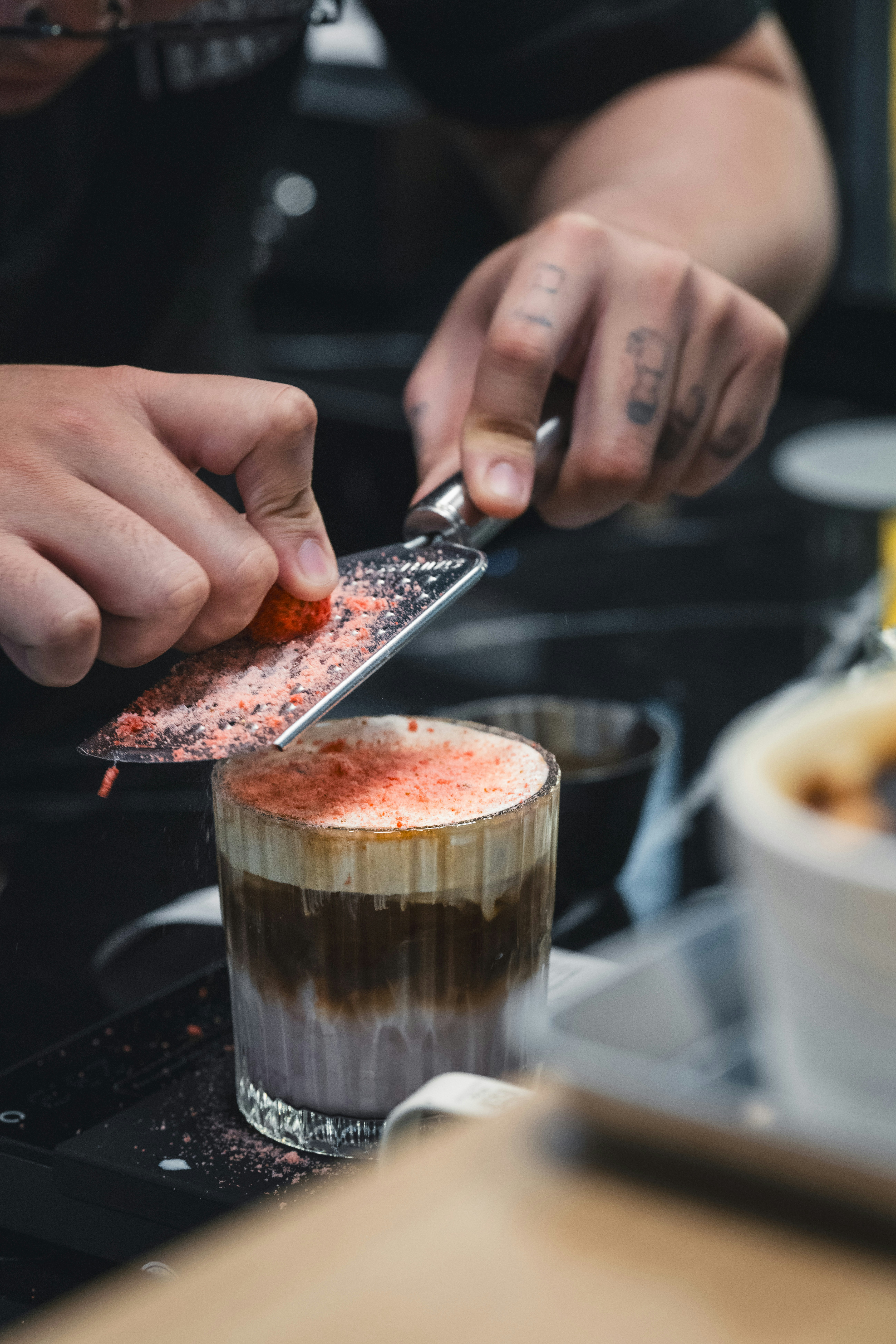 Ritual of the Salted Frost: Grating Garnish onto a Layered Latte