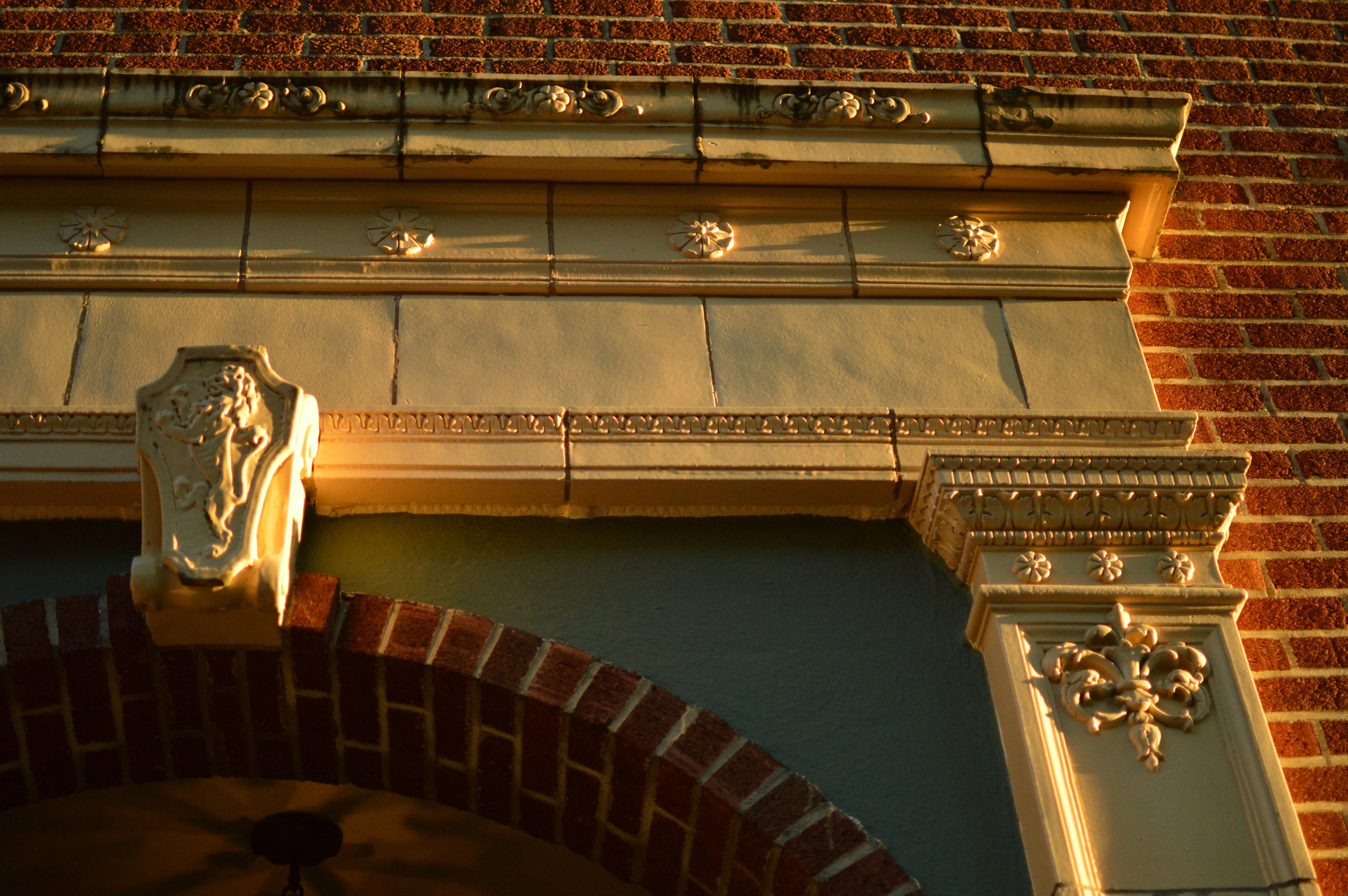 Sunlit Cornice and Arch: A Studied Moment in Brick and Stone