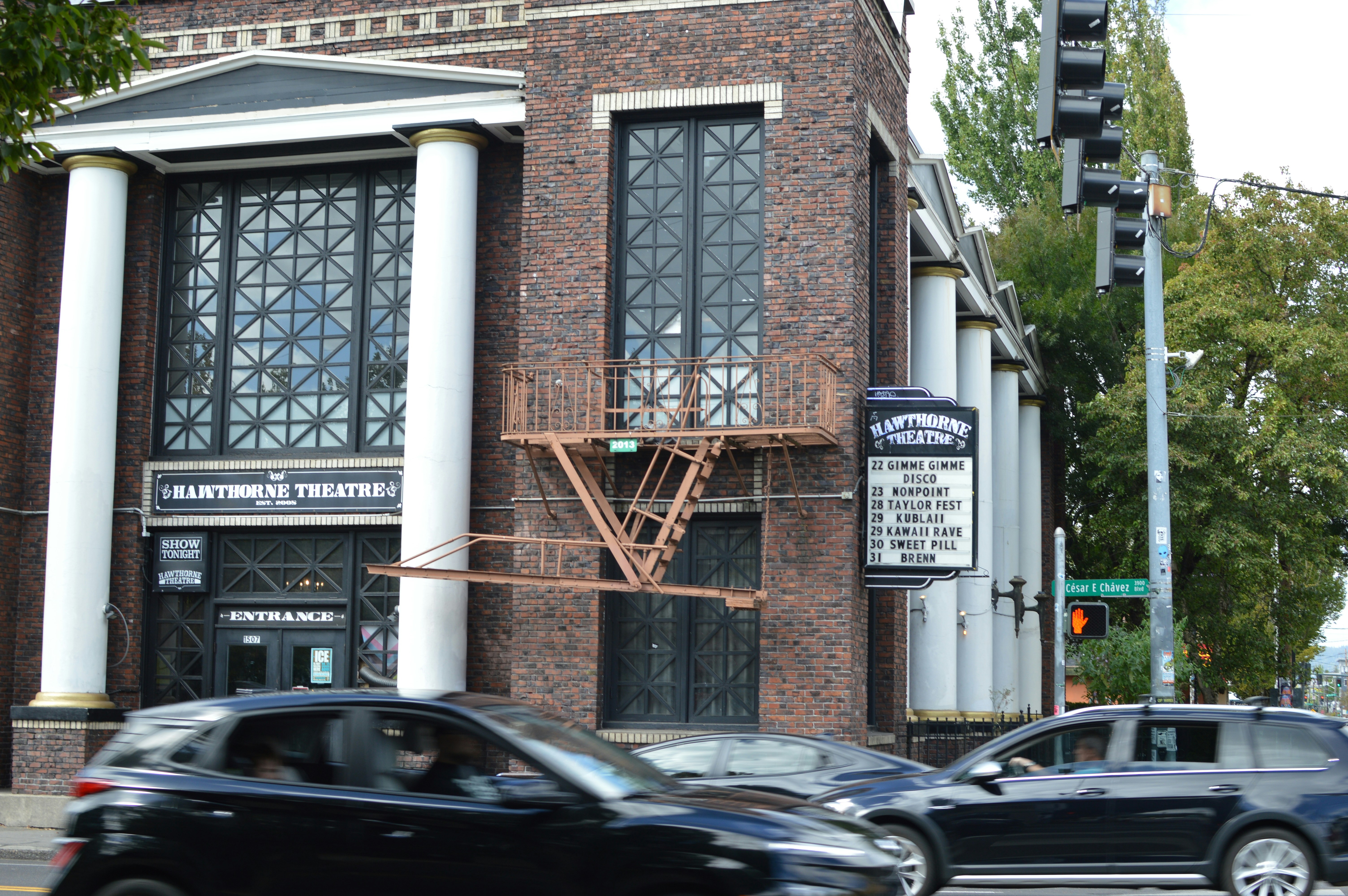 Urban Theater Facade: Brick Theatre with Prominent Signage and Moving Traffic