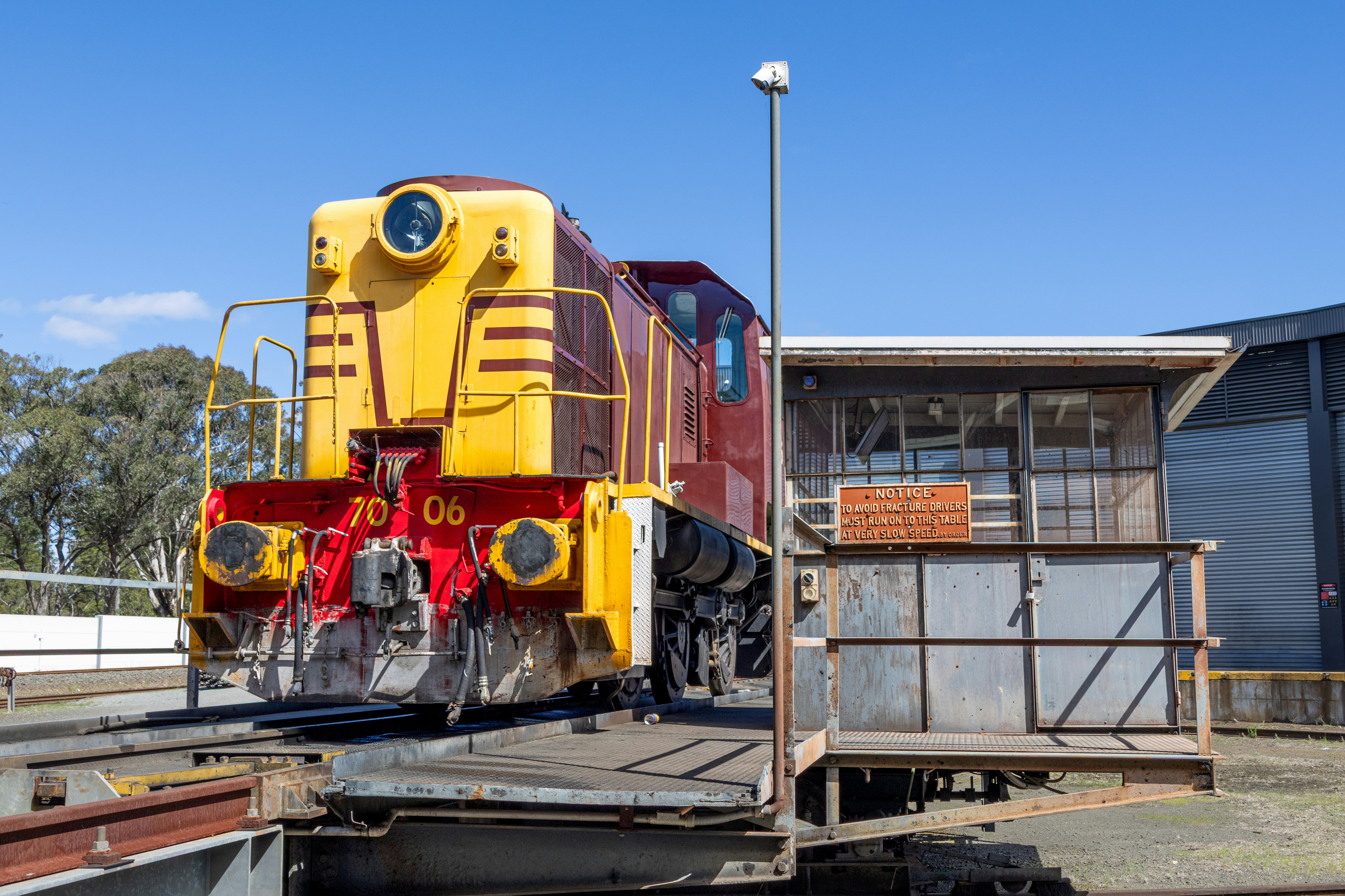 Majestic Railside Workhorse: A Red-Yellow Locomotive Watcher at Dusk