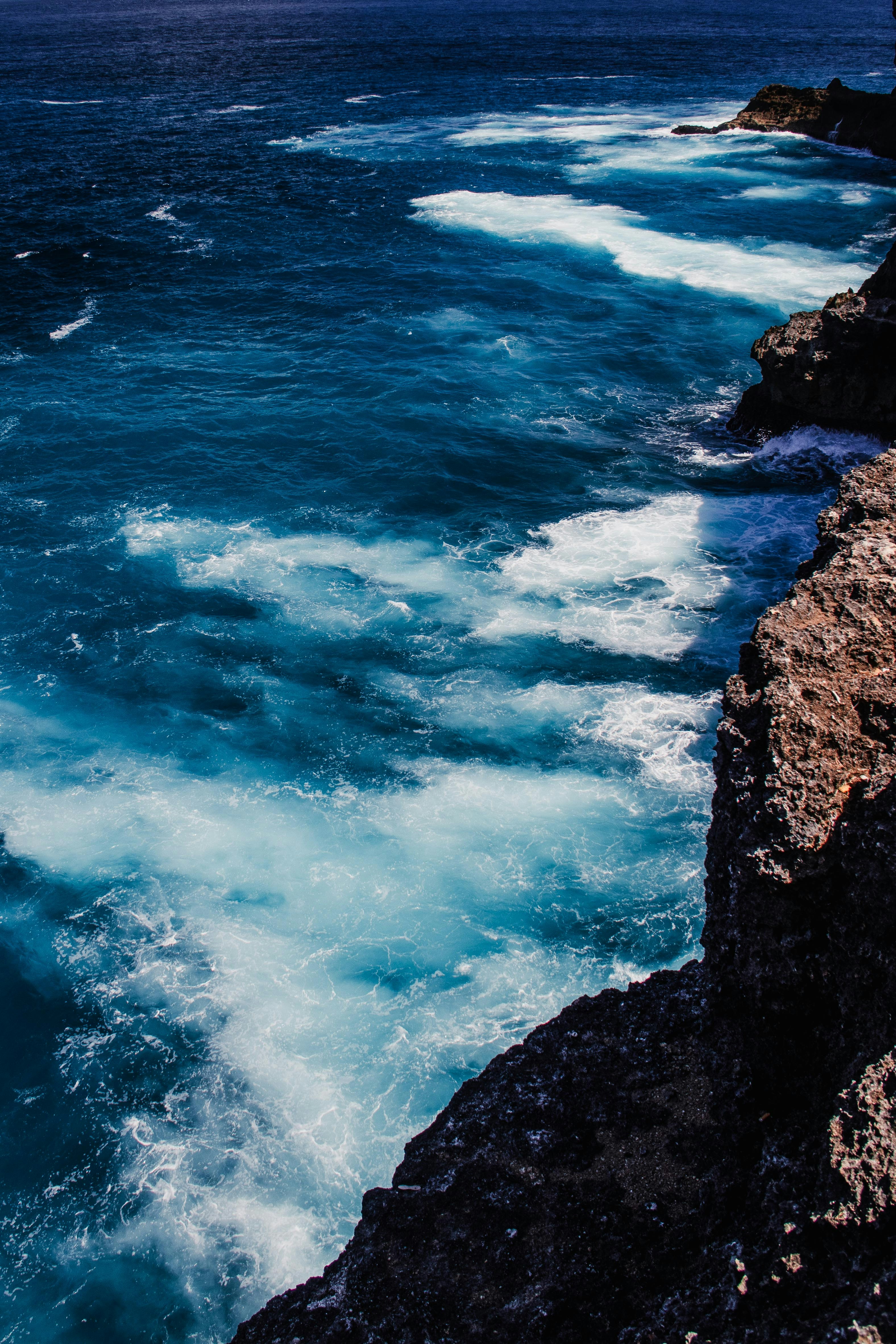 Cliffside Breakers: Turquoise Surges Against Rugged Rock