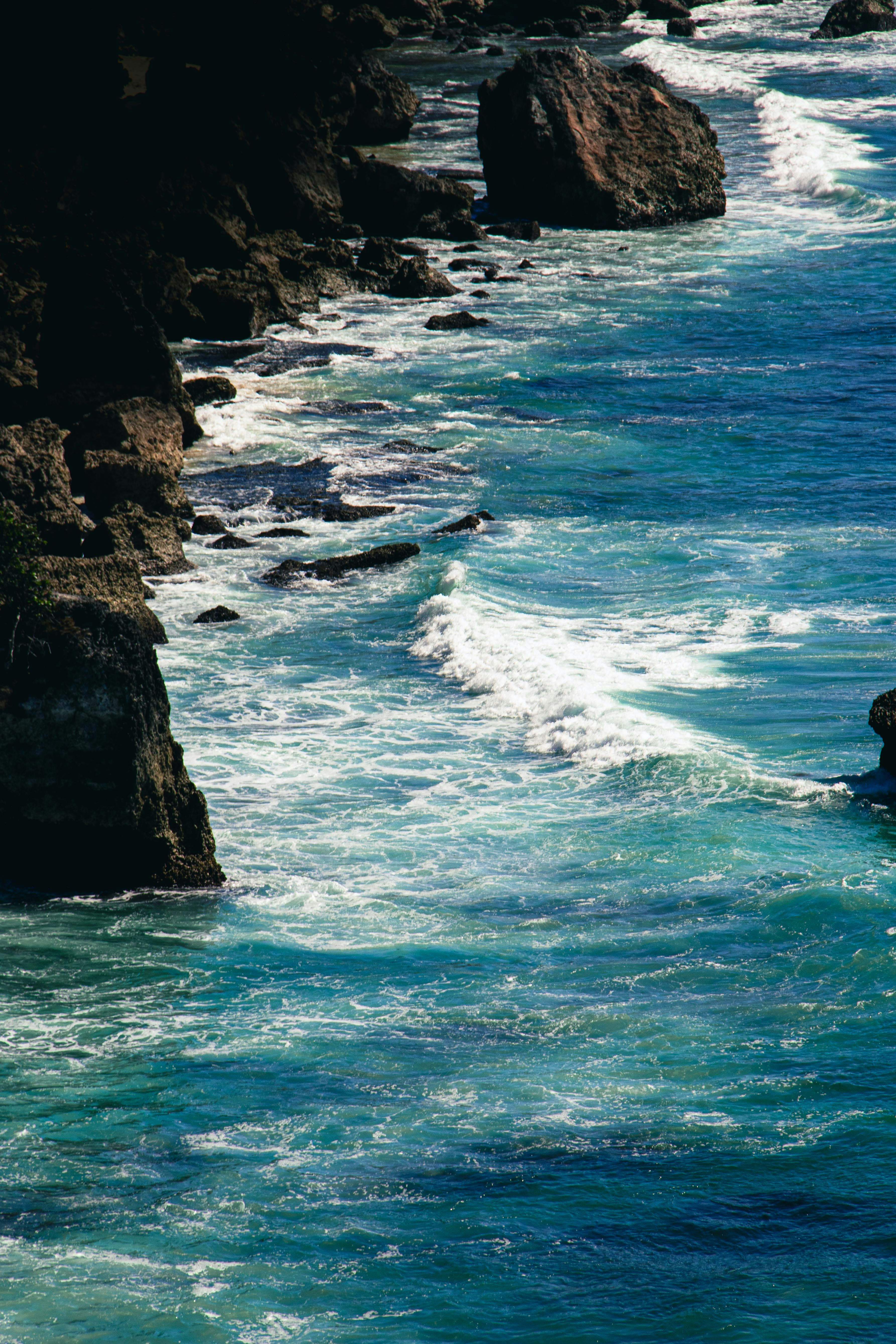 Coastal Cliffline: Turquoise Waves Against Weathered Rock