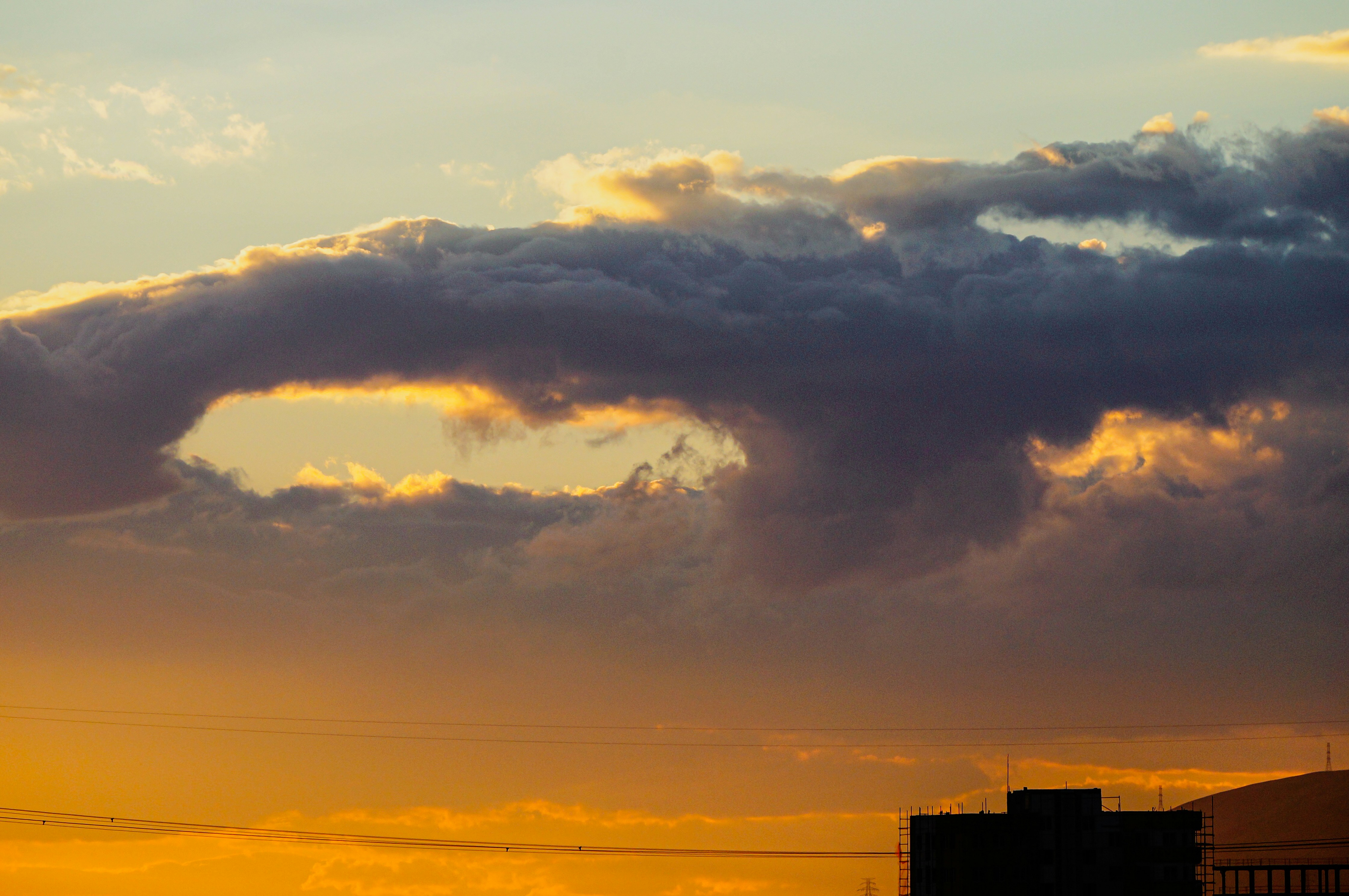 Golden Aperture: Cloud Bank on a Quiet Horizon