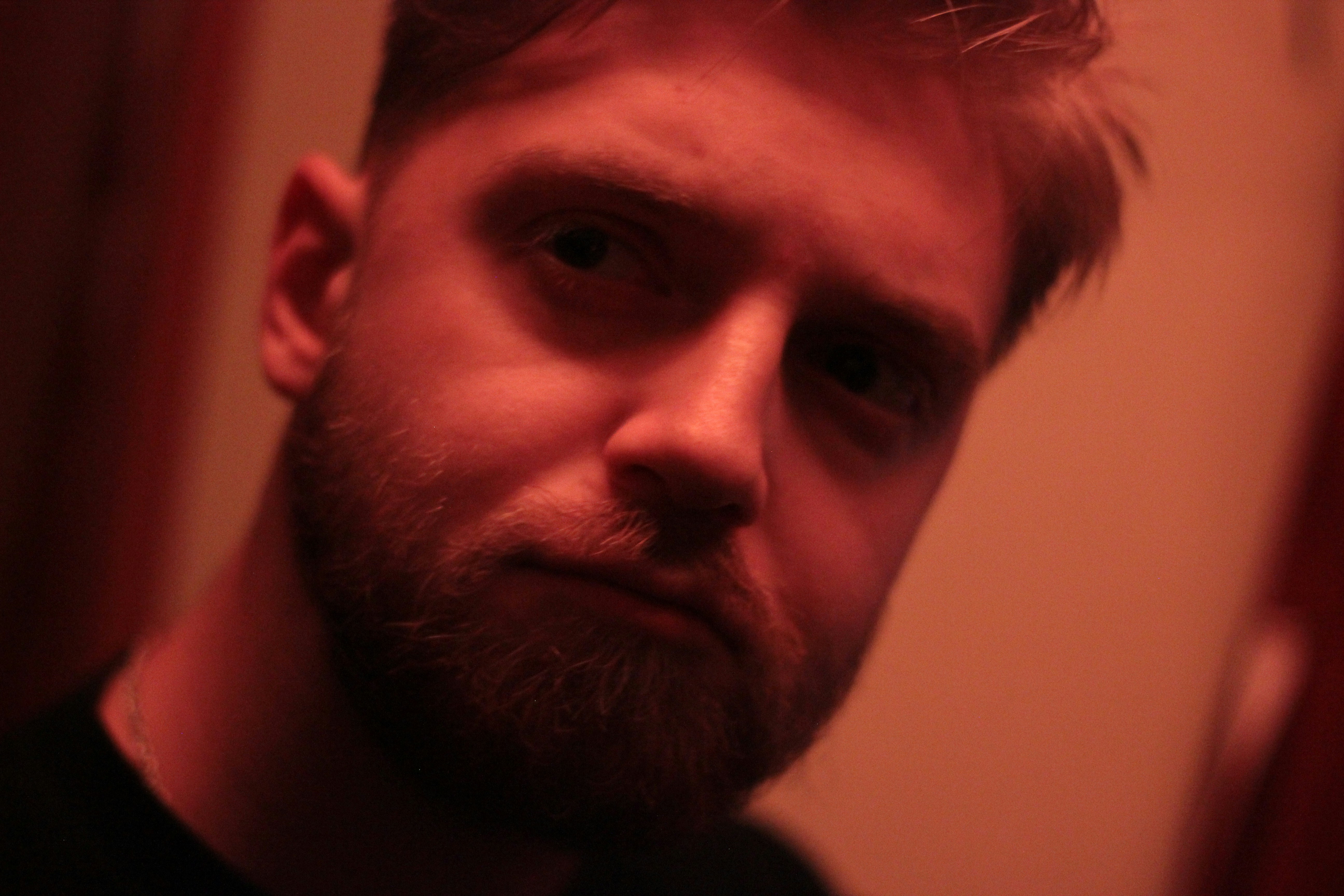 Dim Portrait in Warm Light: A Penumbra of Focus on the Beard and Gaze