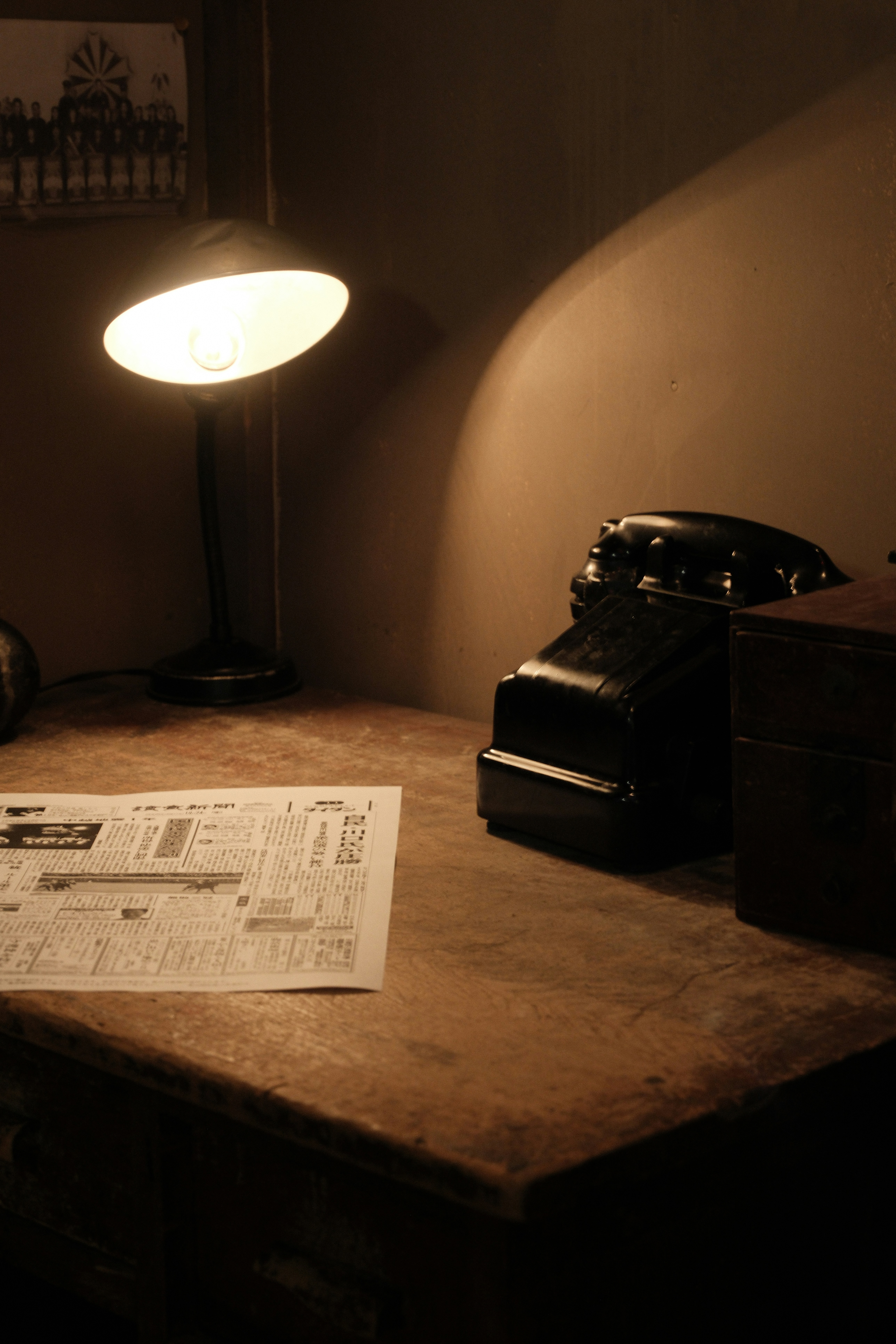 Lamplight over a Quiet Desk: An Old Phone and Newspaper