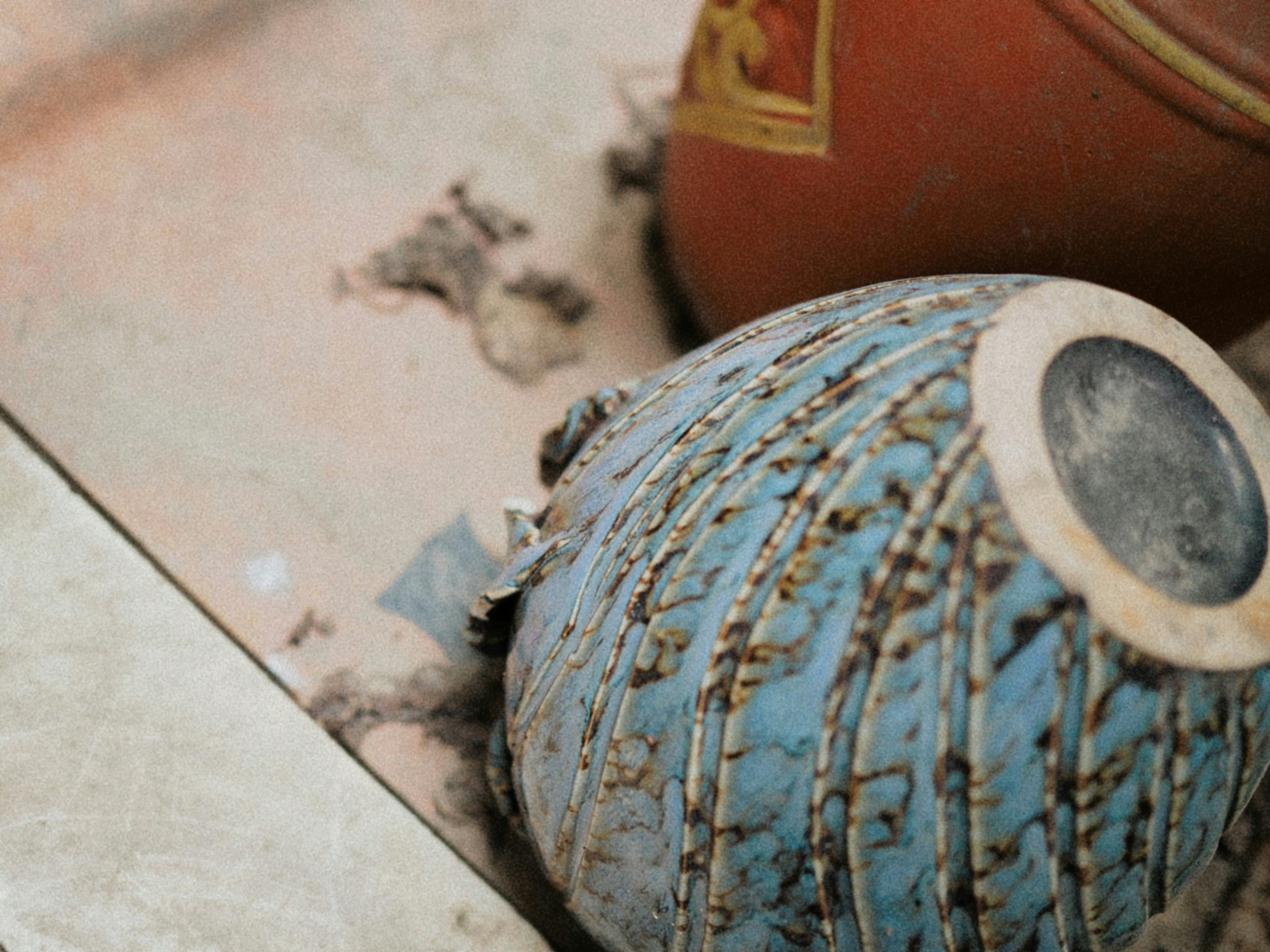 Weathered Ceramics: Blue Spindle Amid Cracked Tiles