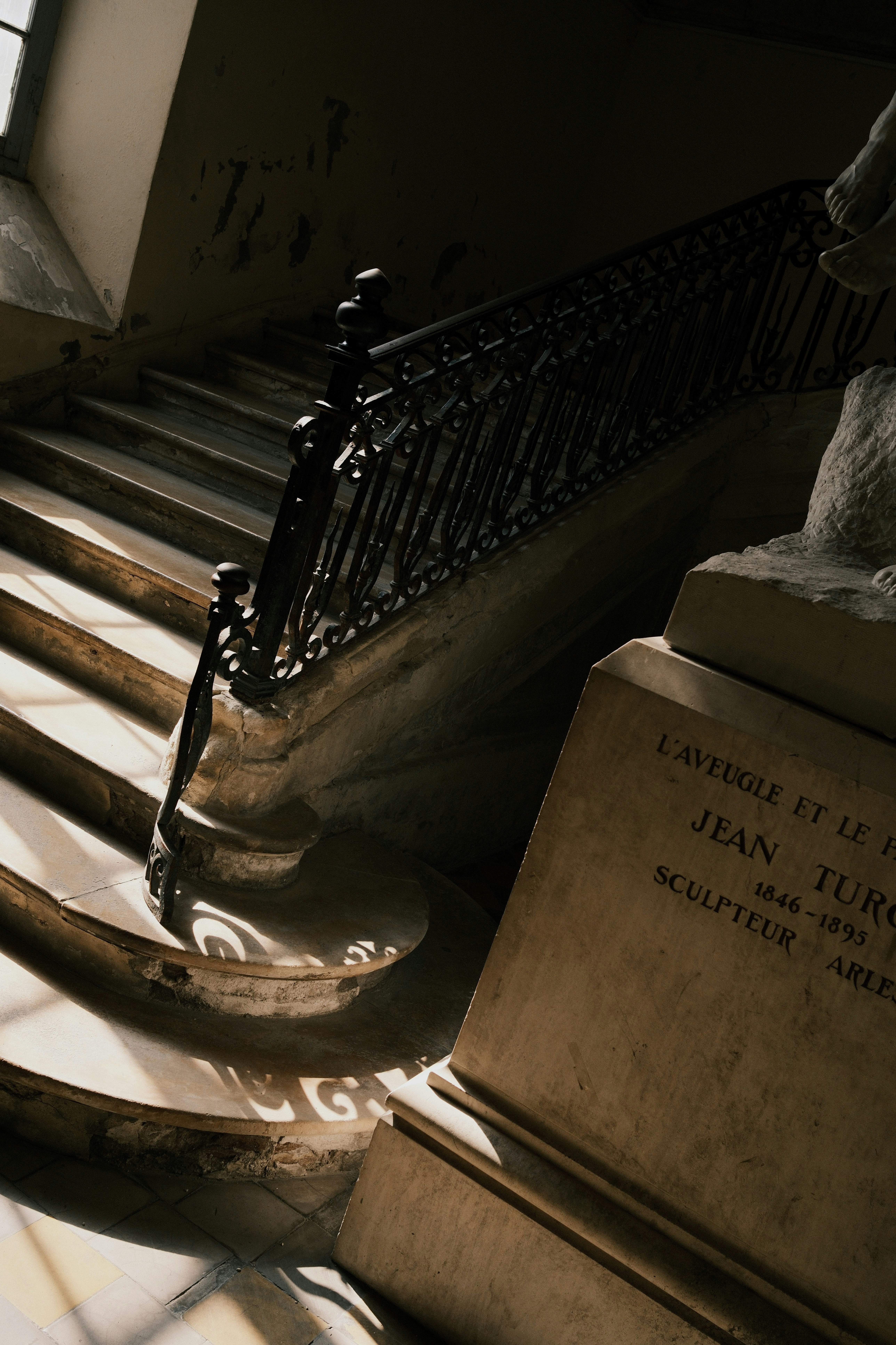 Shadowed Staircase and Timeworn Plaque