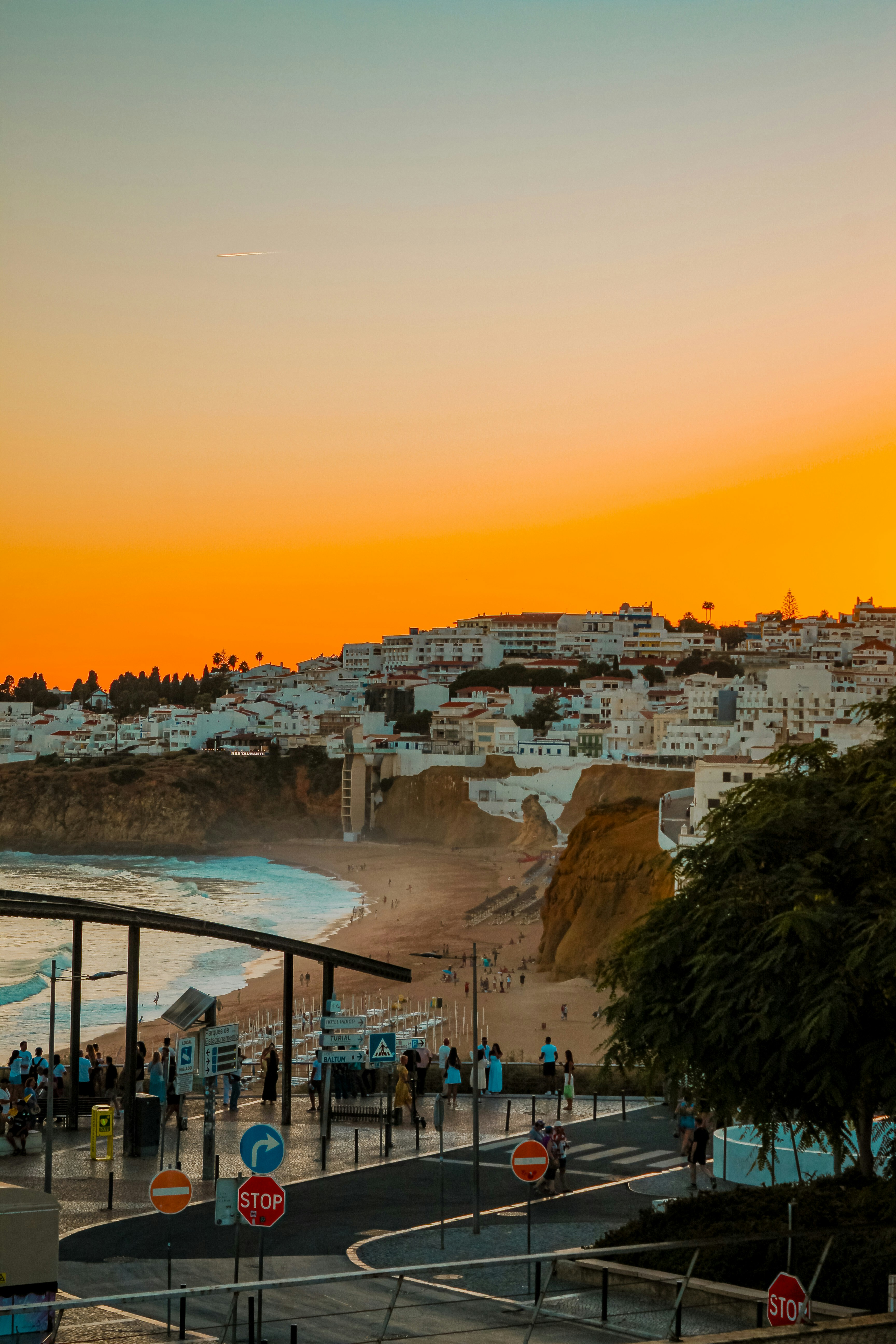Sunset Over a Cliffside Town: A Coastal Pathwalk Through Orange Skies