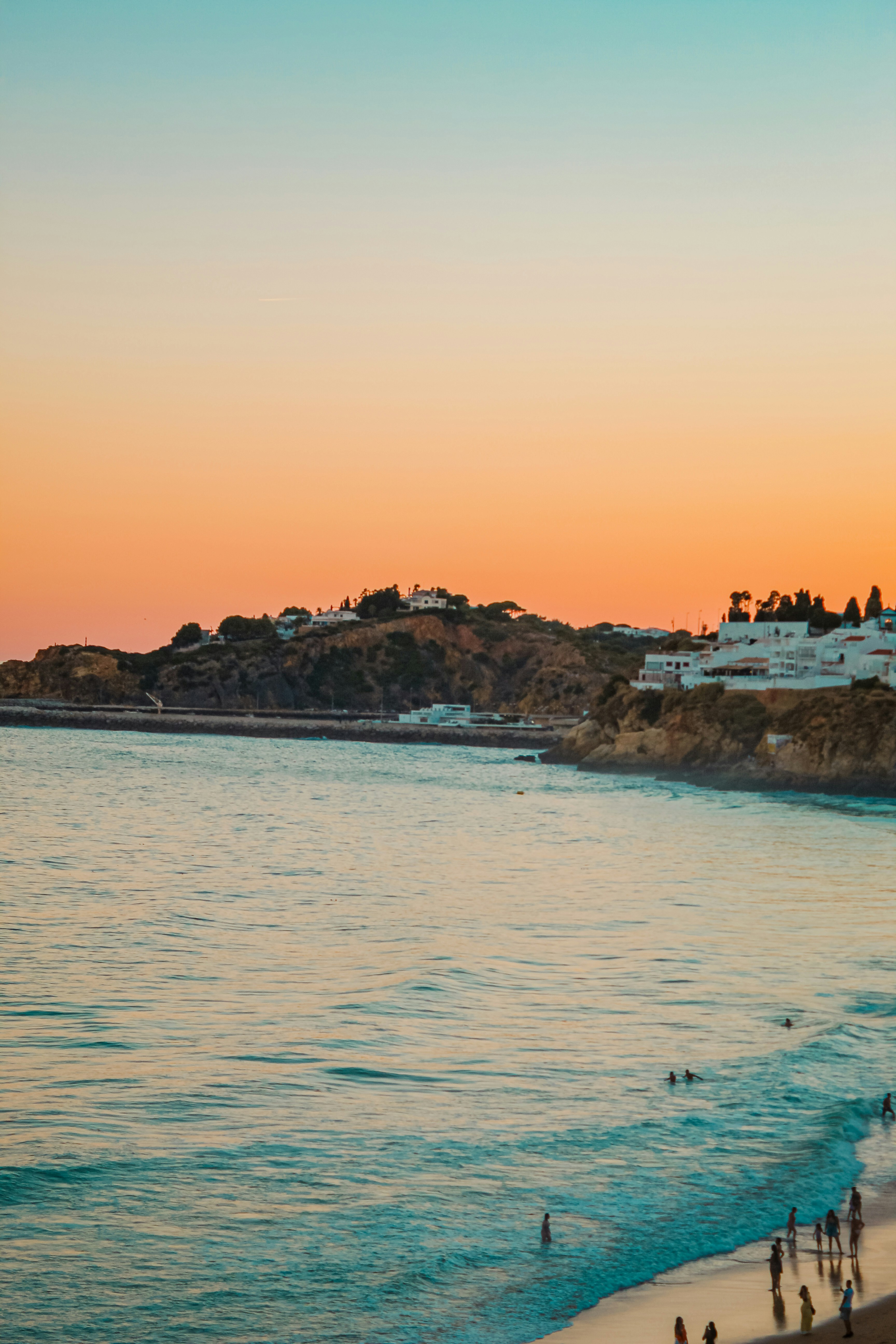 Sunset Village: Coastal Homes Silhouetted Against a Calm Sea