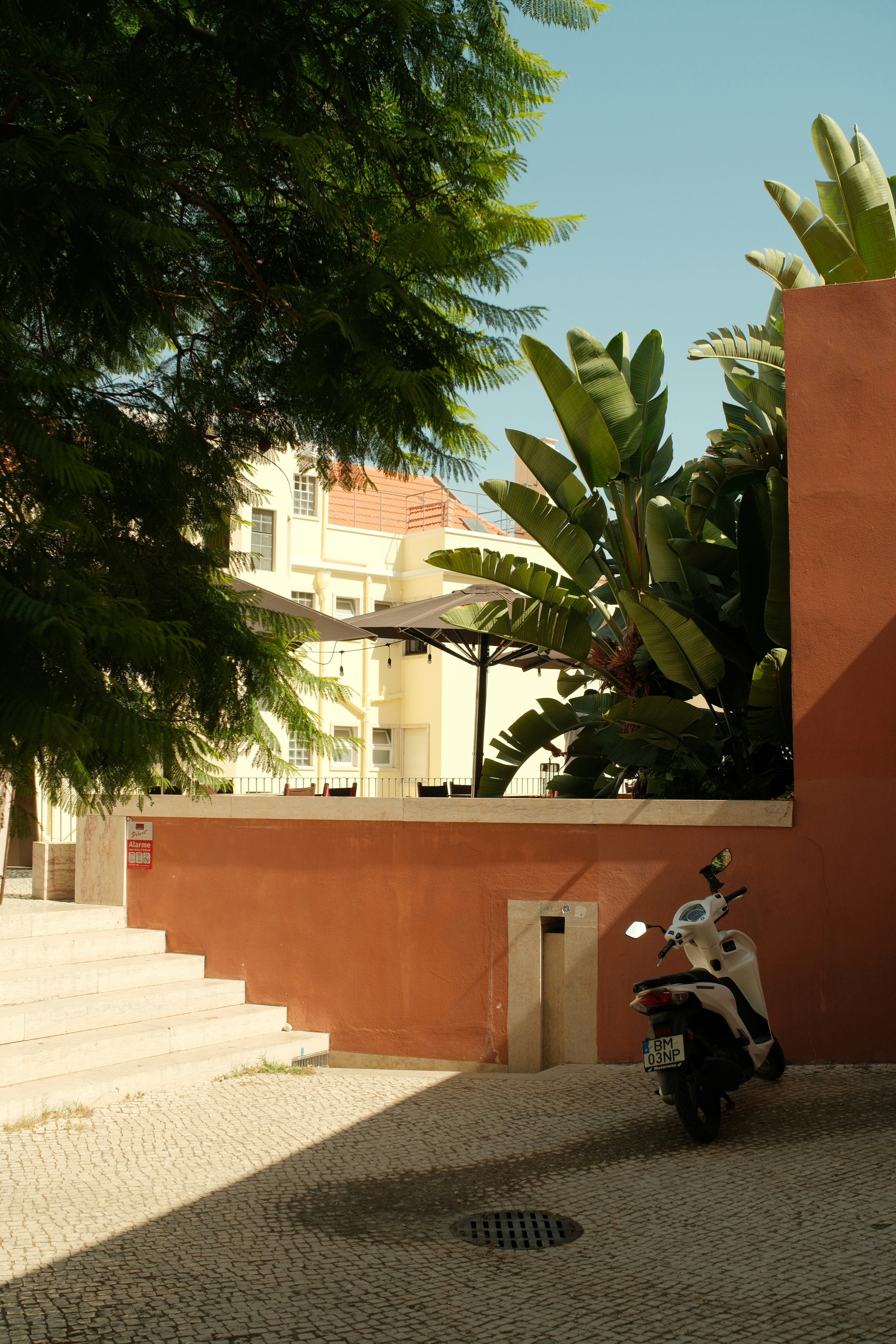 Sunlit Terrace and Scooter at a Warm Mediterranean Corner
