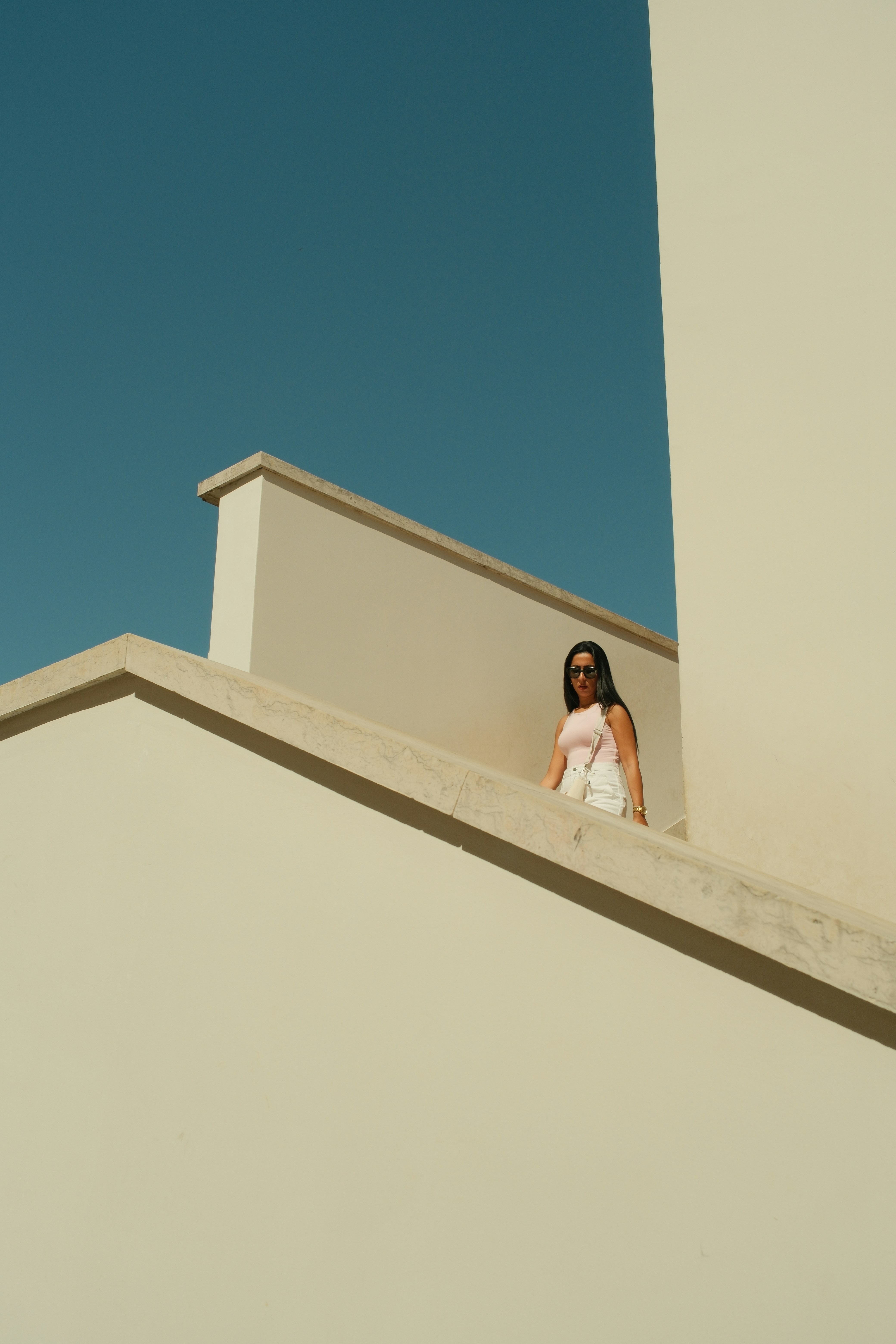 Stepped Light: A Figure on Geometric Architecture Under Cerulean Sky