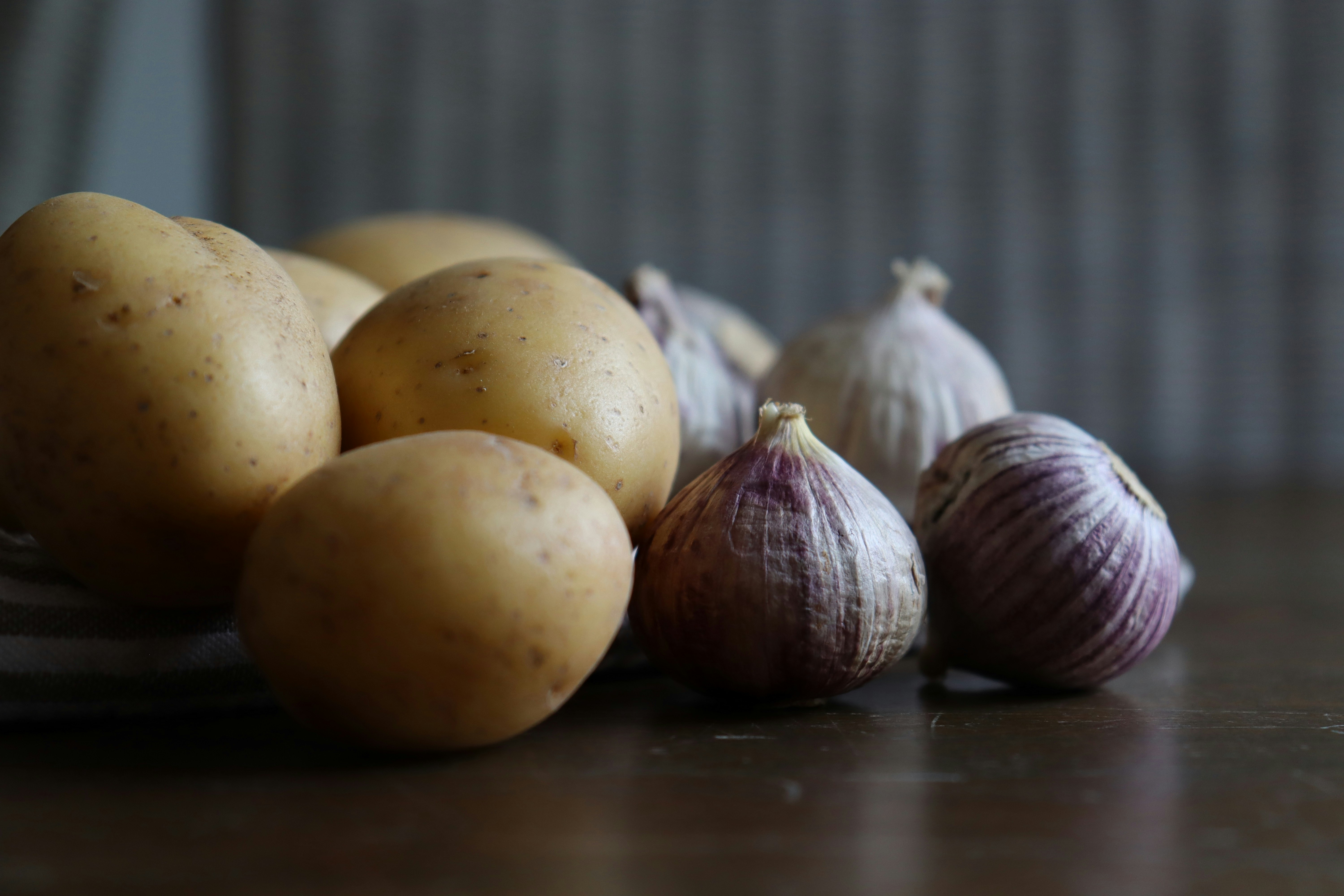 Quiet Harvest: A Still Life of Potatoes and Garlic on a Wooden Table