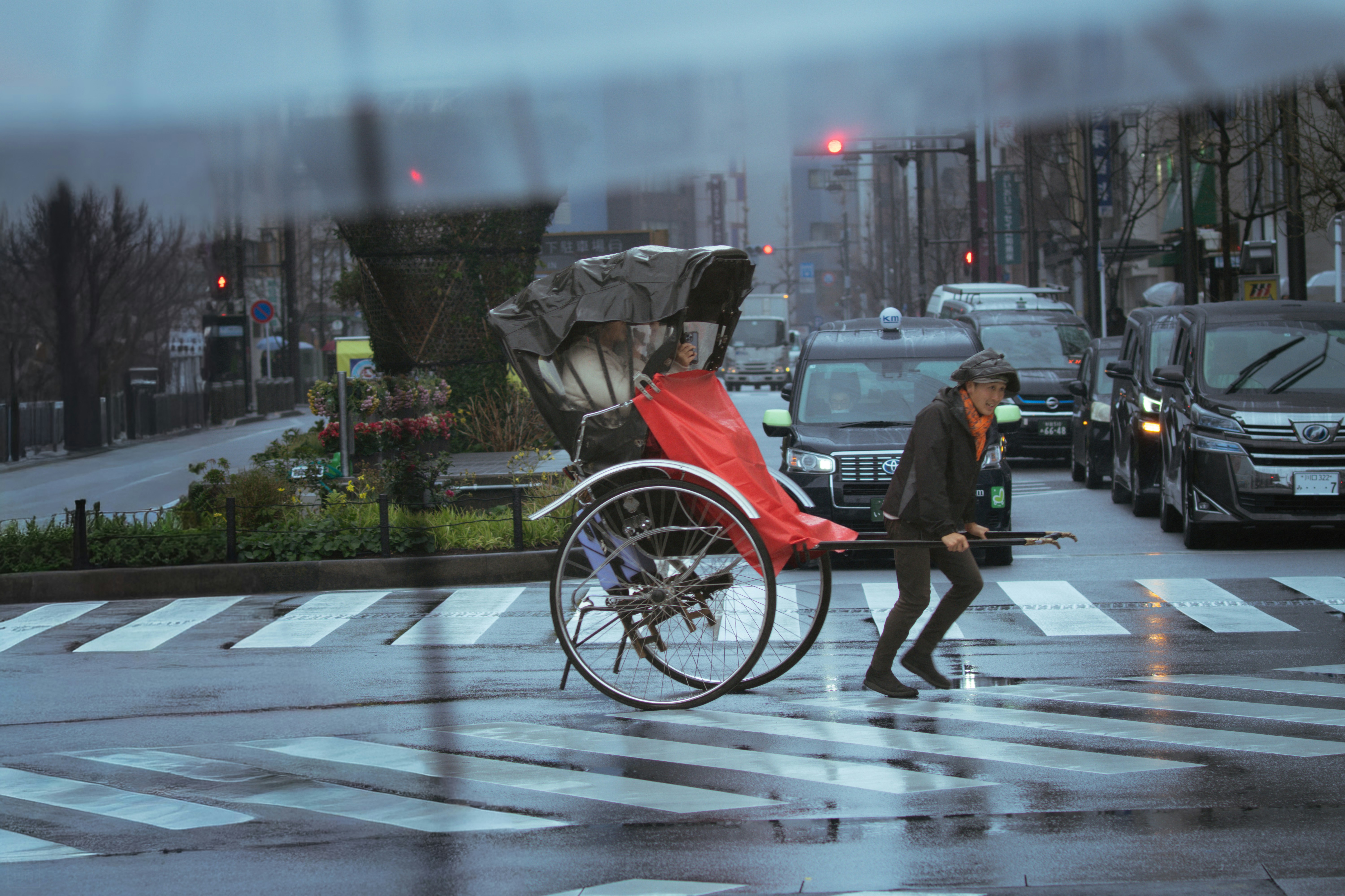 Crosswalk in Rain: A Pedestrian and a Rickshaw in Motion