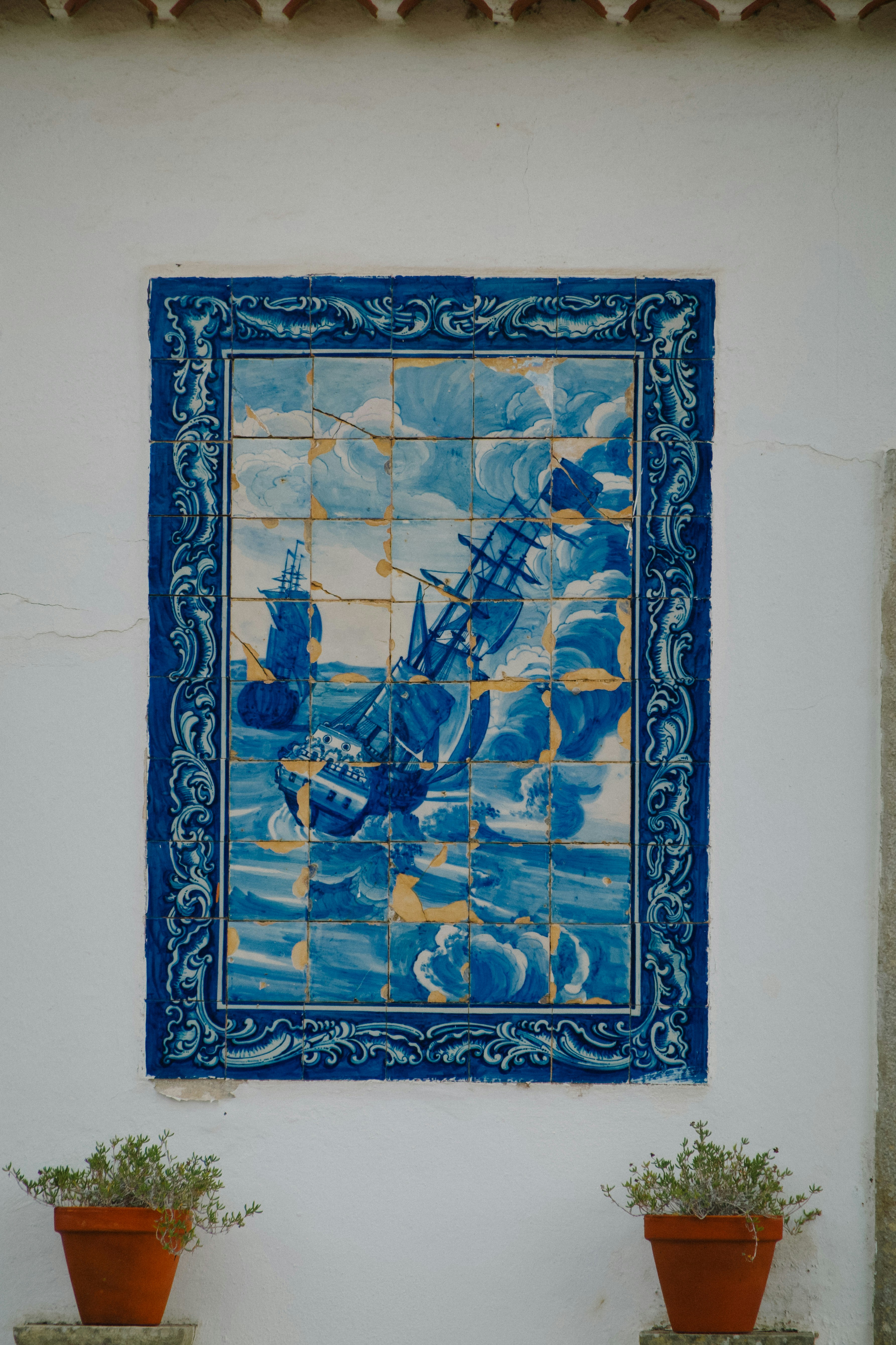 Blue Ceramic Ship Tiles on White Wall with Potted Plants
