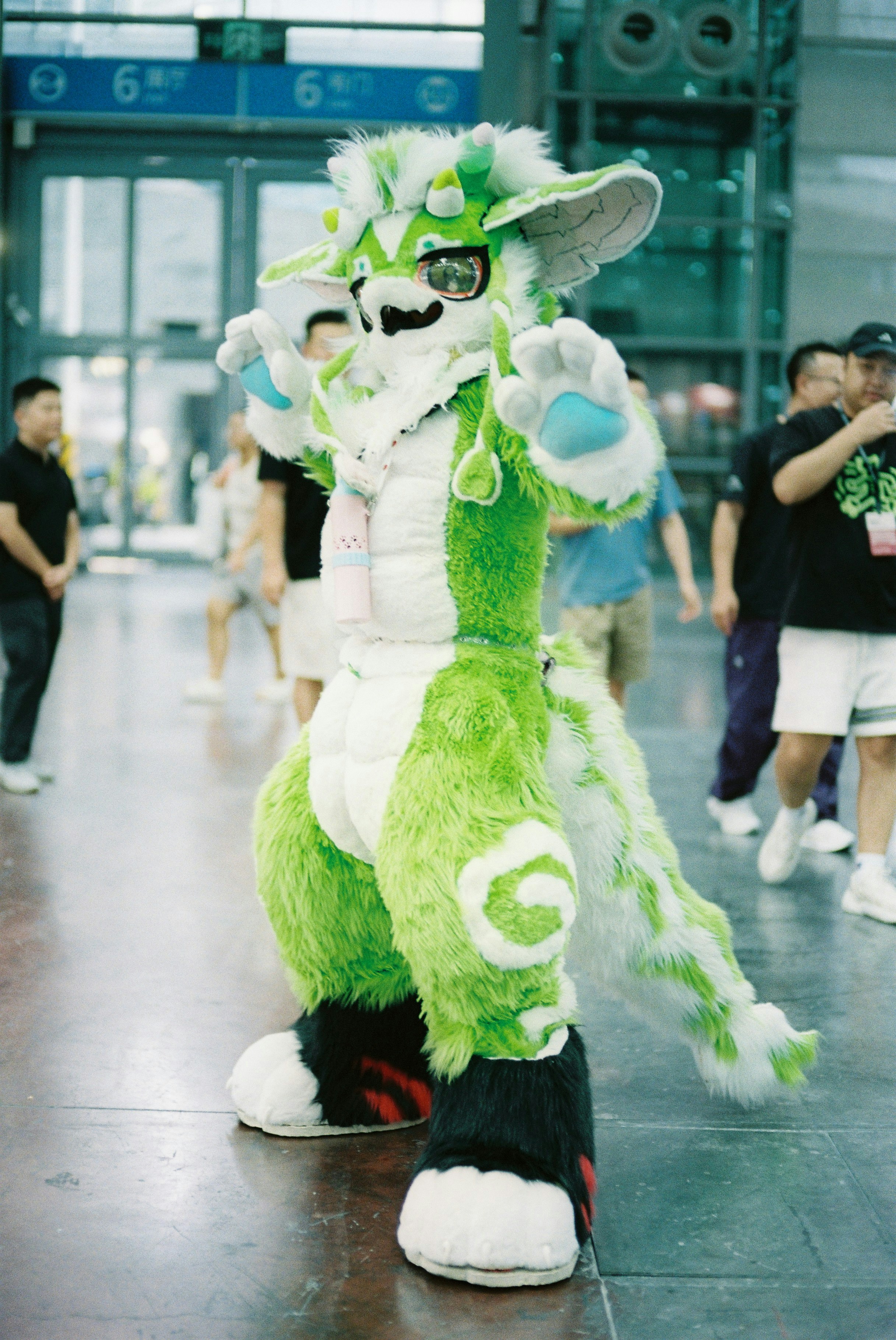 Neon Dragon Mascot Croons in a Busy Expo Hall