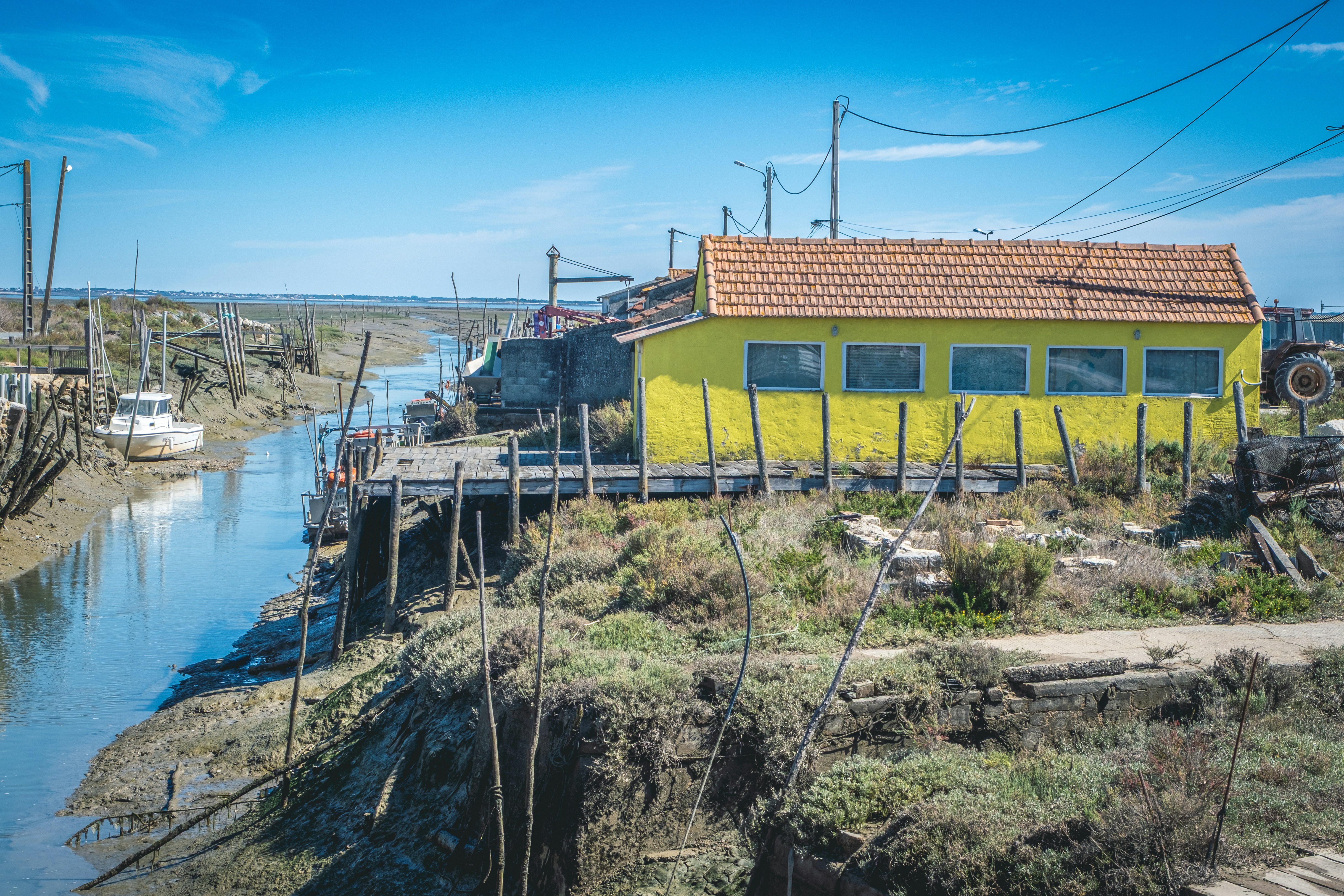 Bright yellow riverside hut by a weathered wooden pier