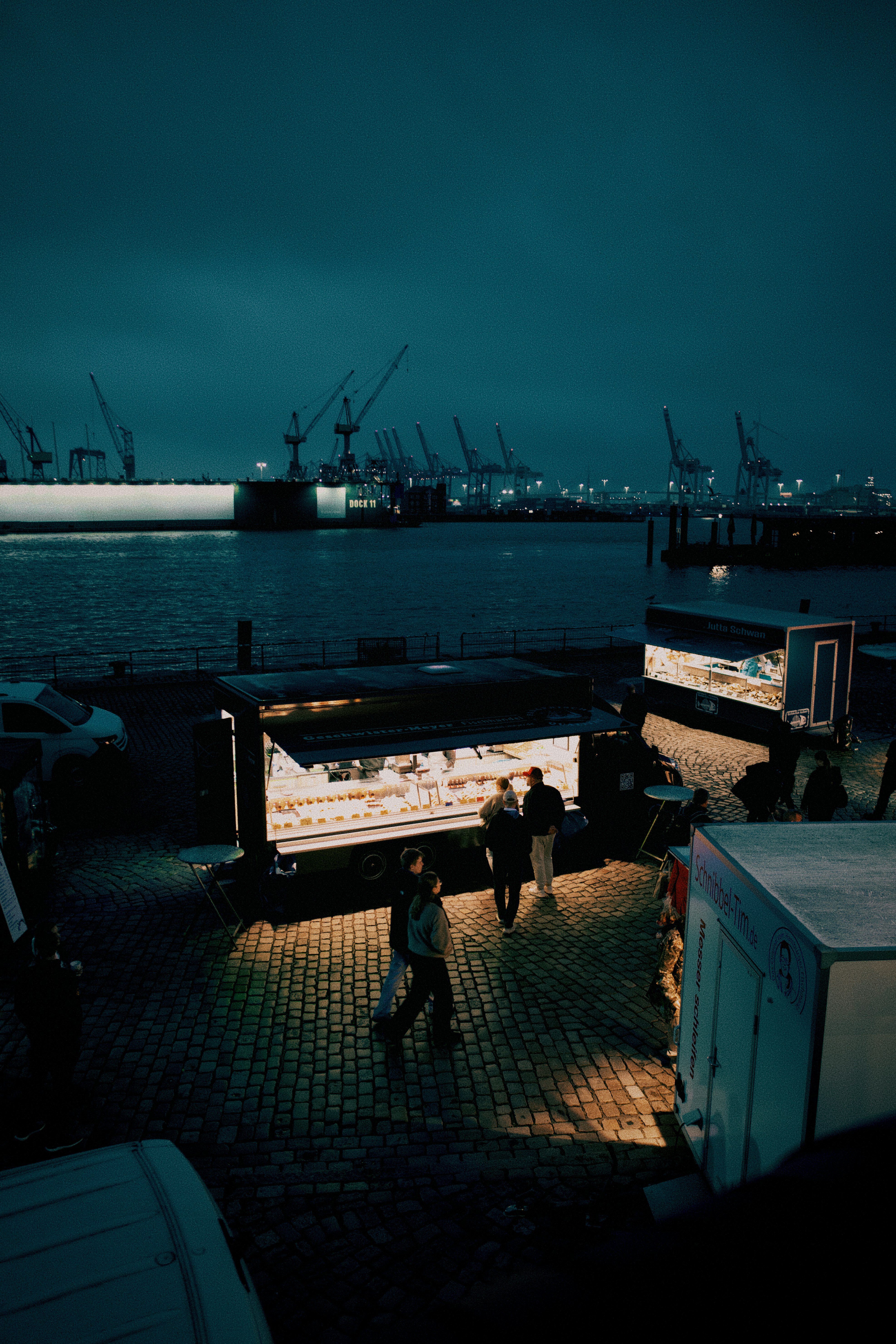 Harbor Night Market: Warm Light Beneath Industrial Skies