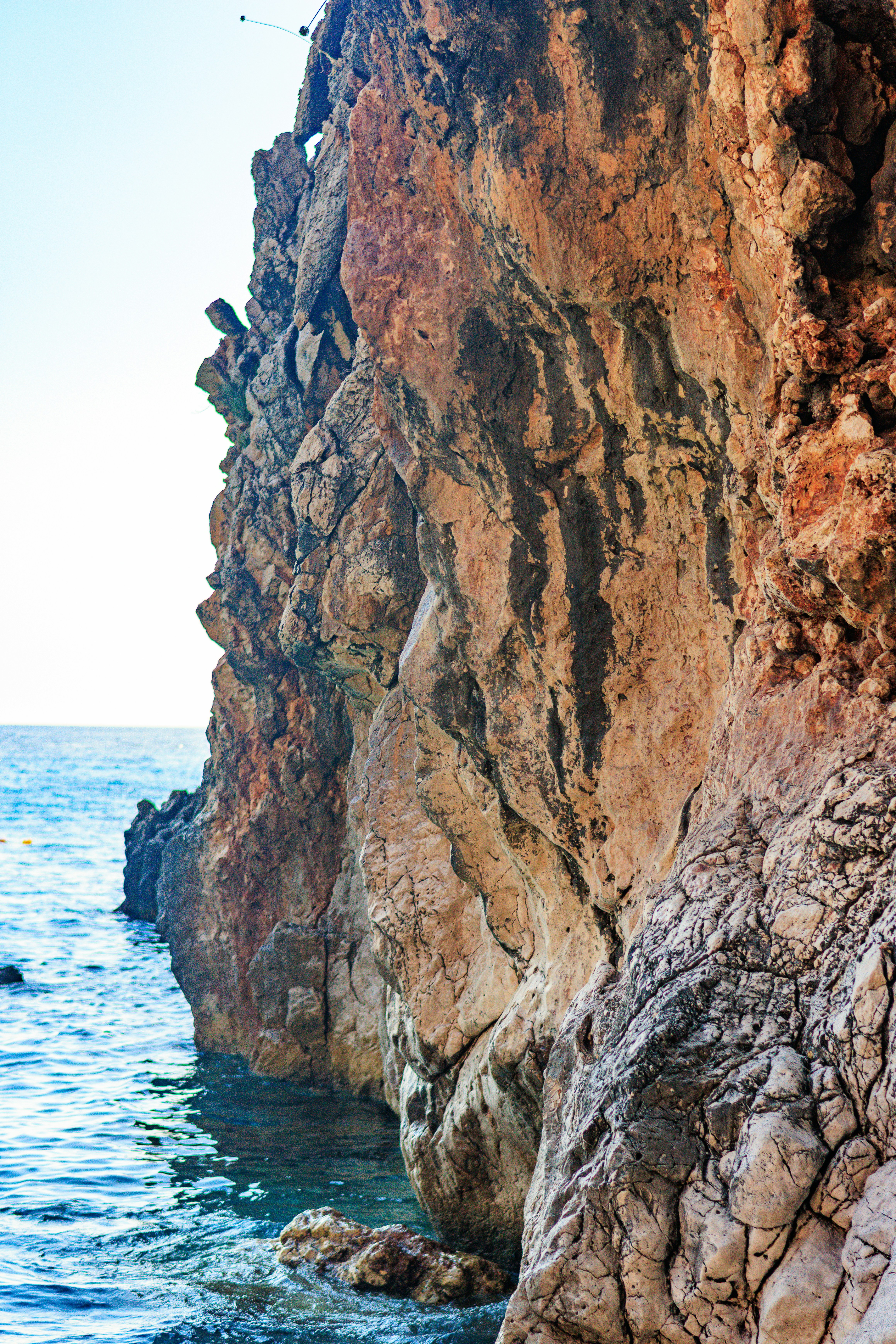Cliffside by the Sea: Sunlit Granite Facade
