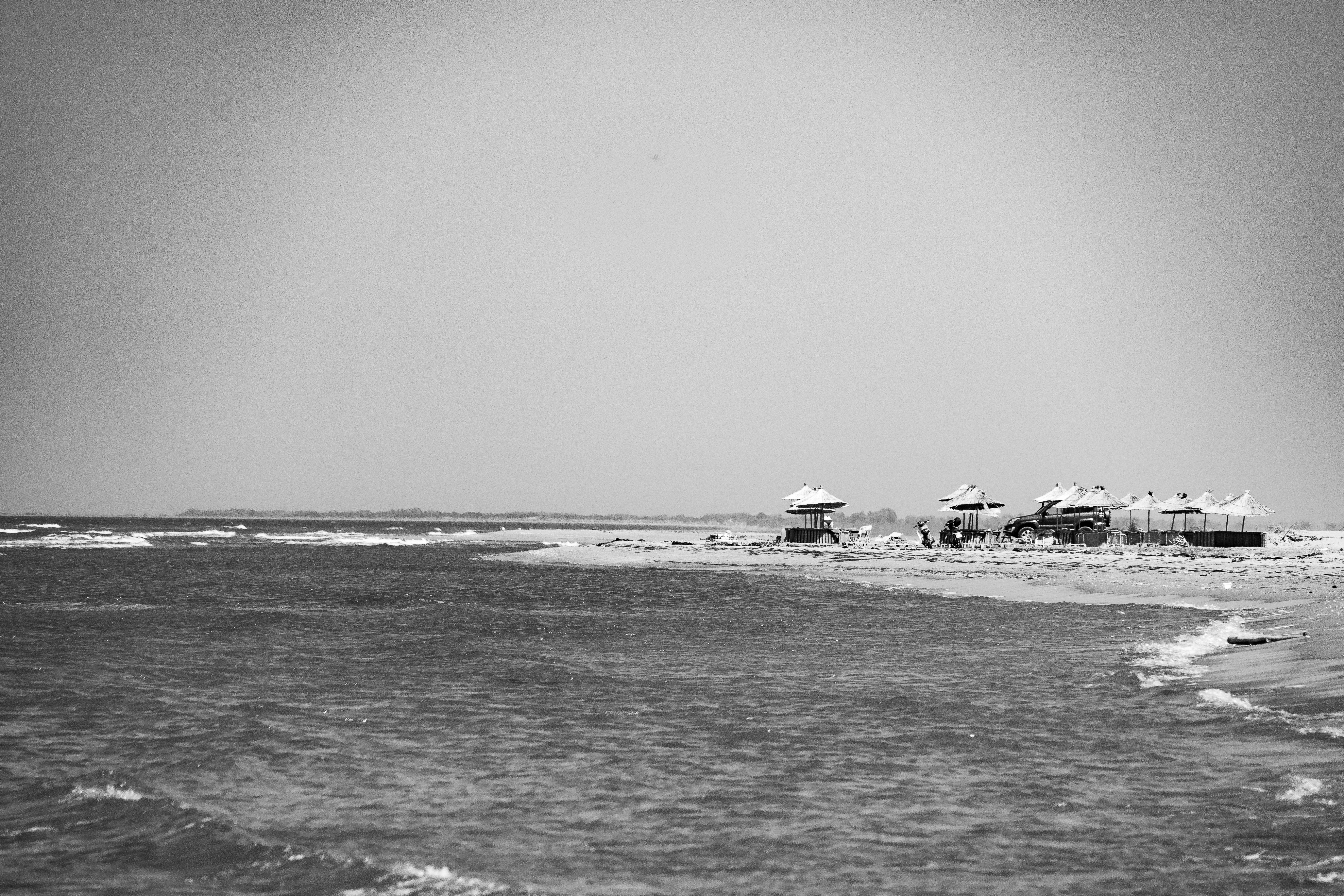 Quiet Horizon: Beachside Structures under Overcast Calm