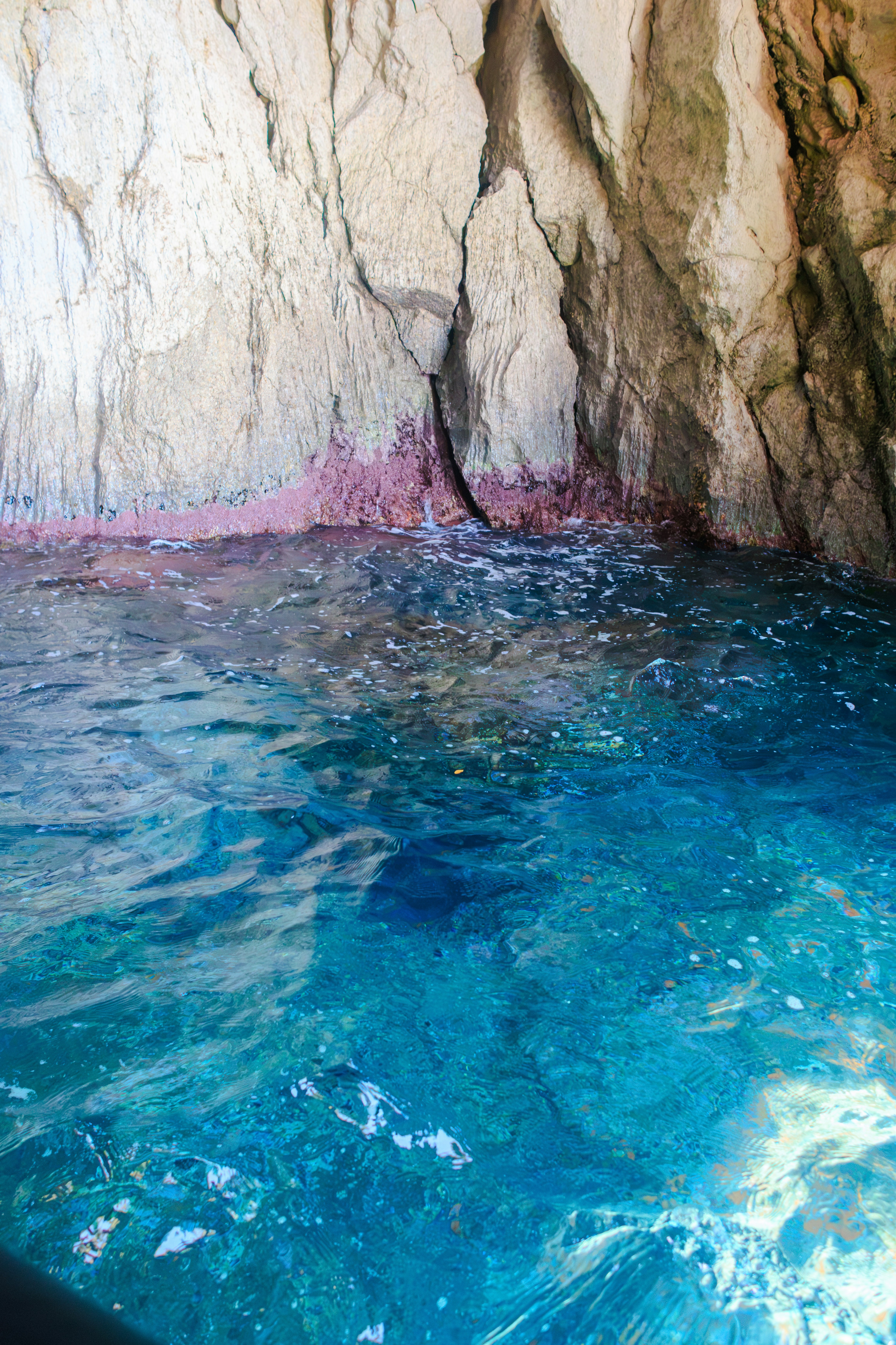 Azure Cavern: Teal Water Lapping the Pink-Backed Rock