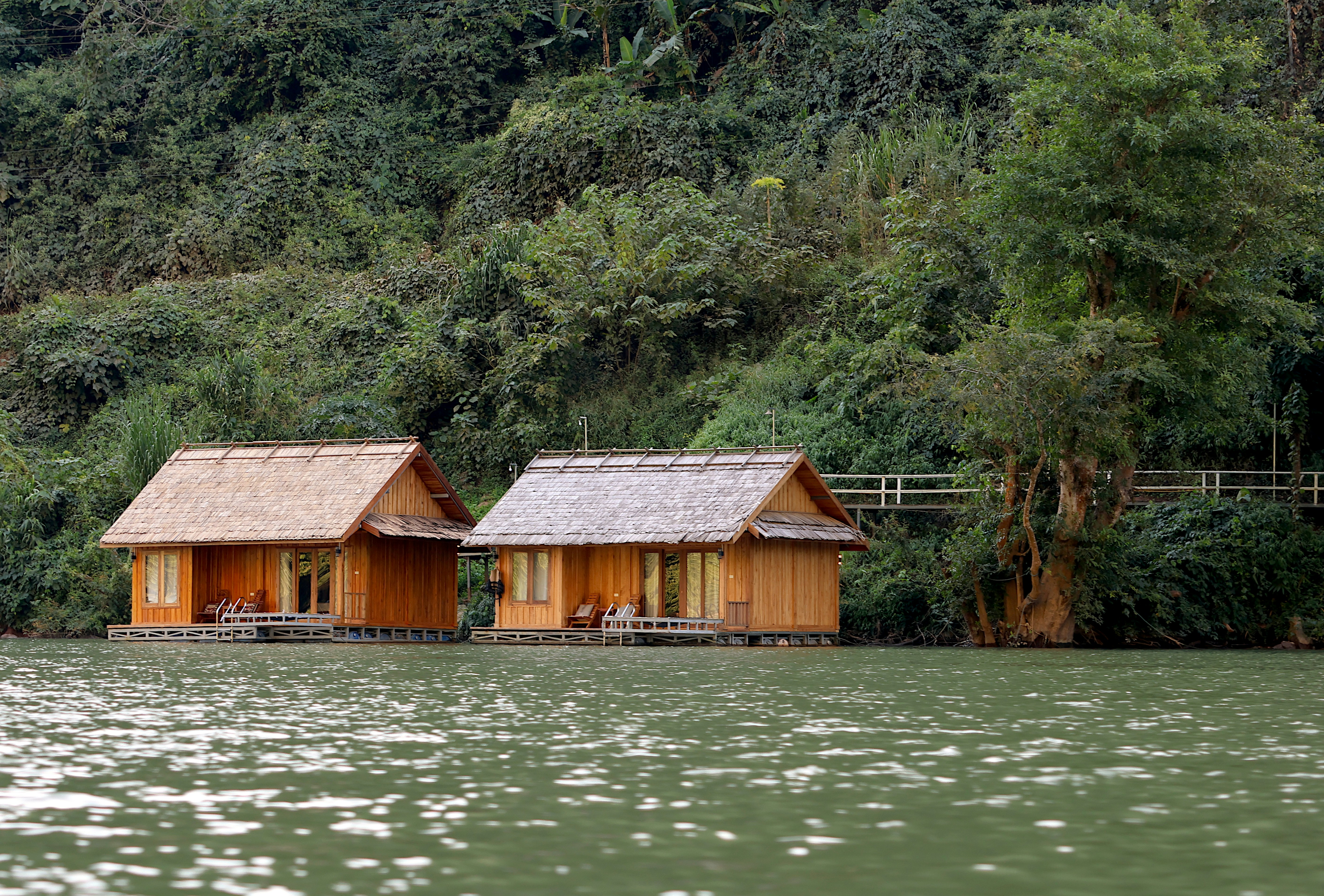 Floating Retreats: Twin Wooden Cabins on a Silvery Lake