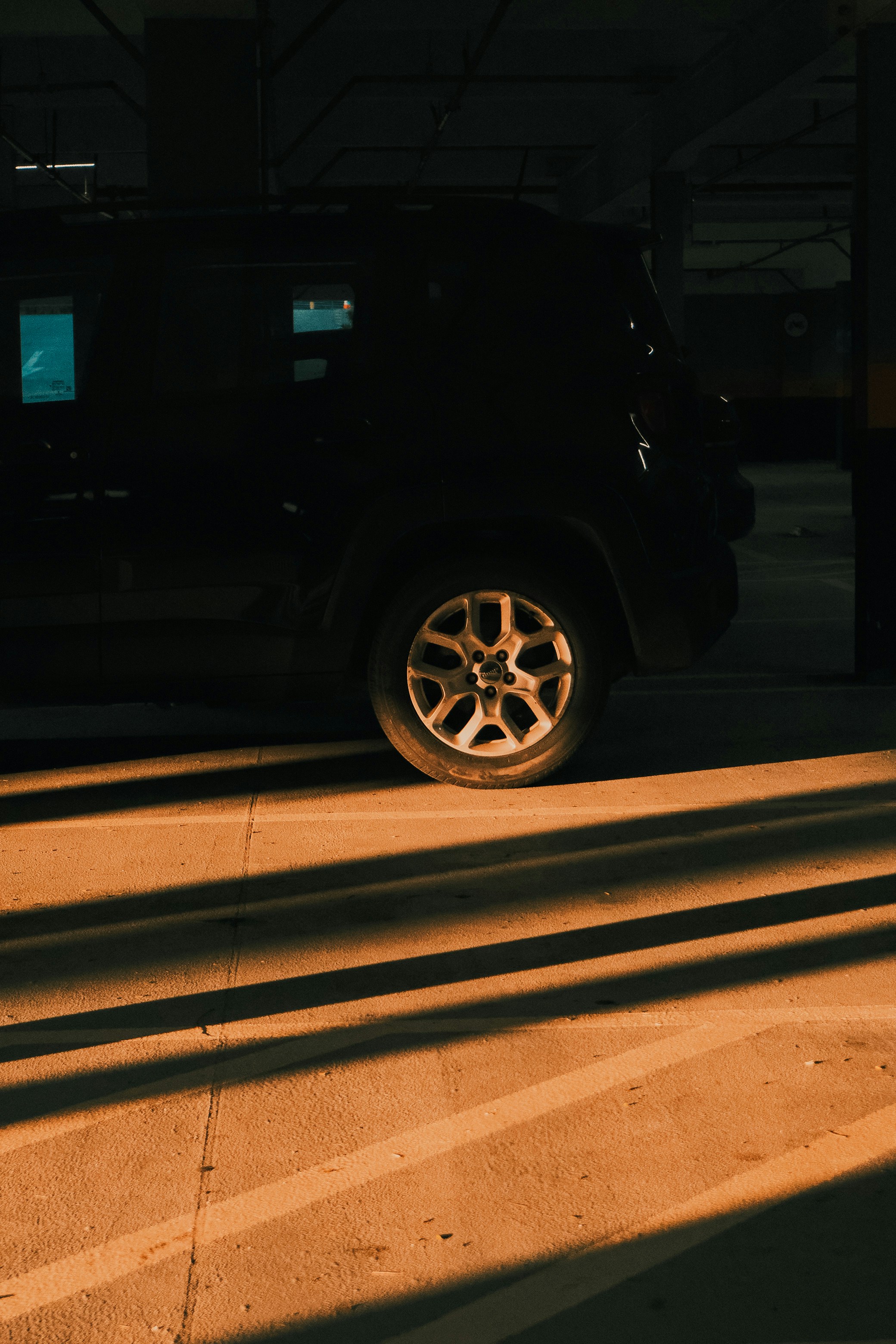 Parking Lot Shadowplay: A Black SUV Under Long Strikes of Sun