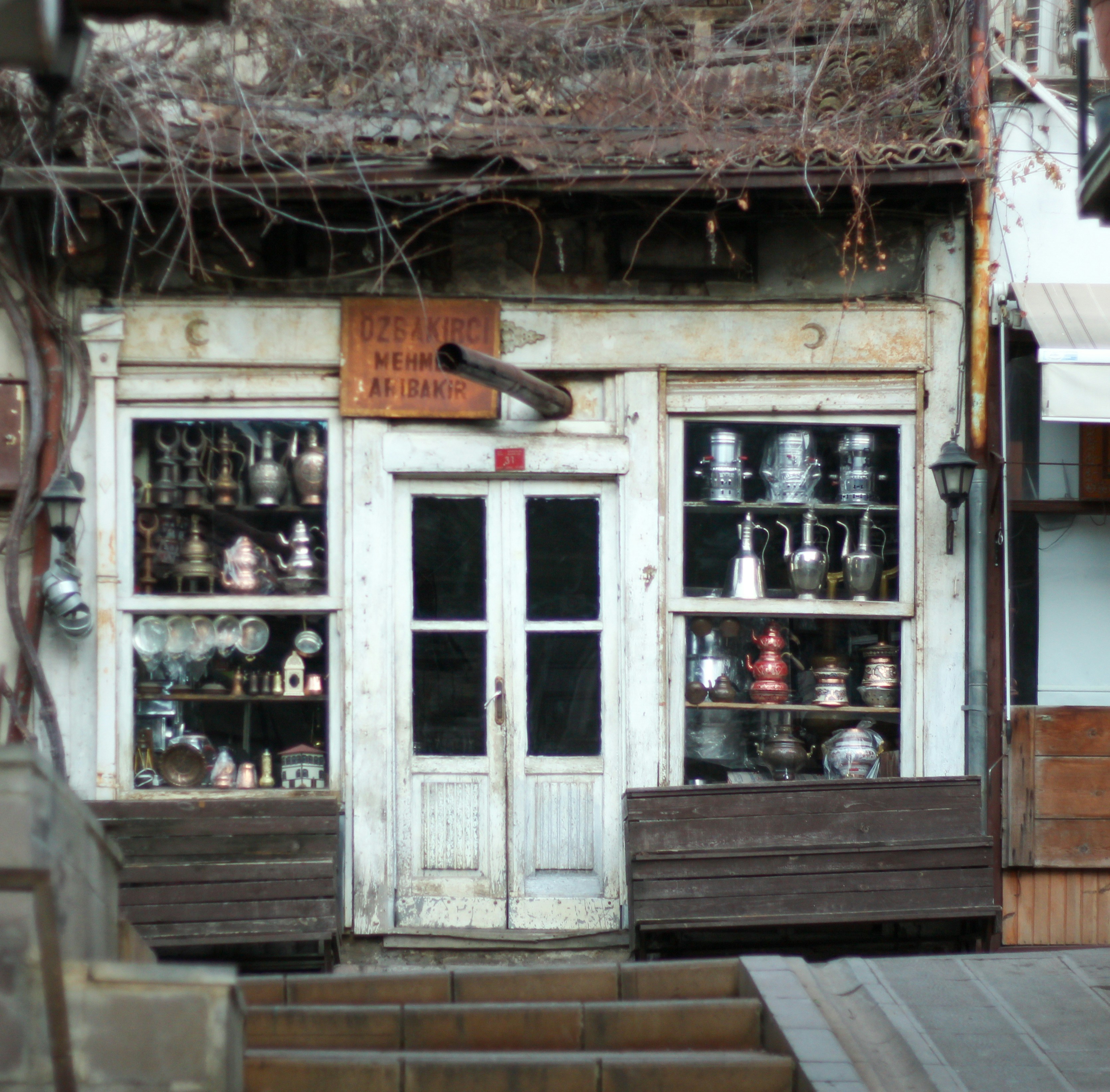 Weathered shopfront: a quiet still life of ceramic ware in a decaying façade