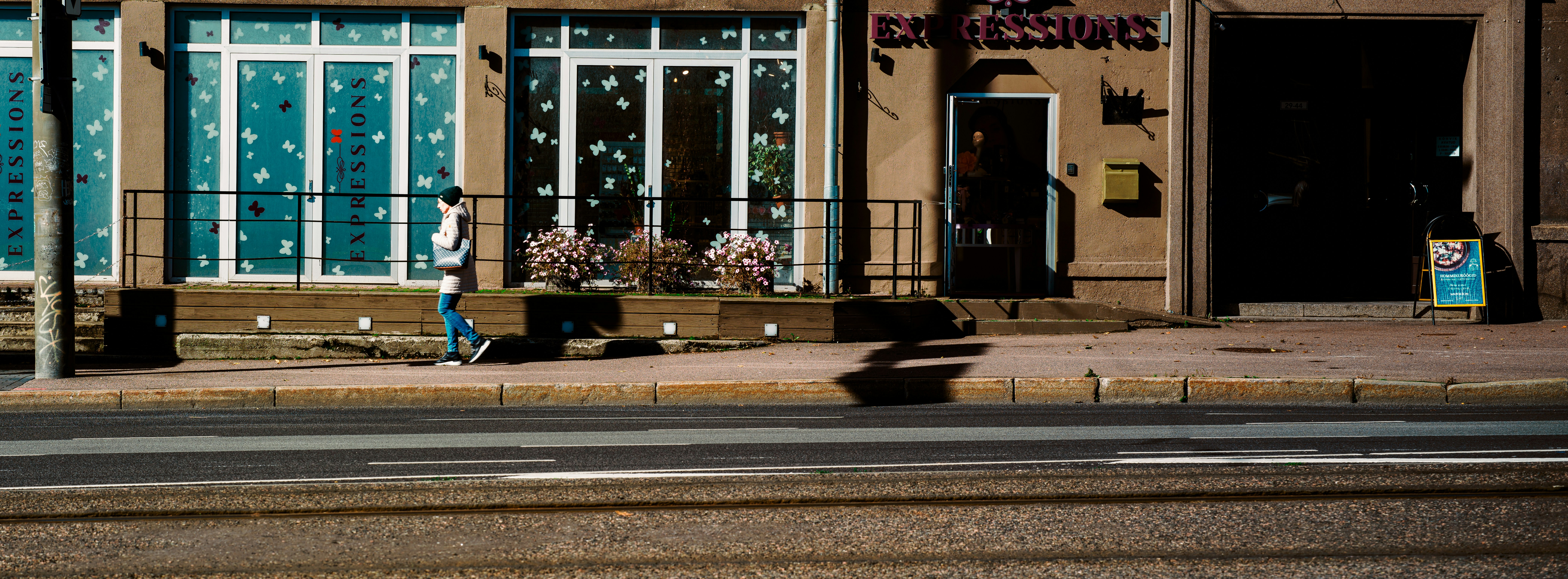 Pedestrian in front of a storefront after a snowfall of confetti-like petals