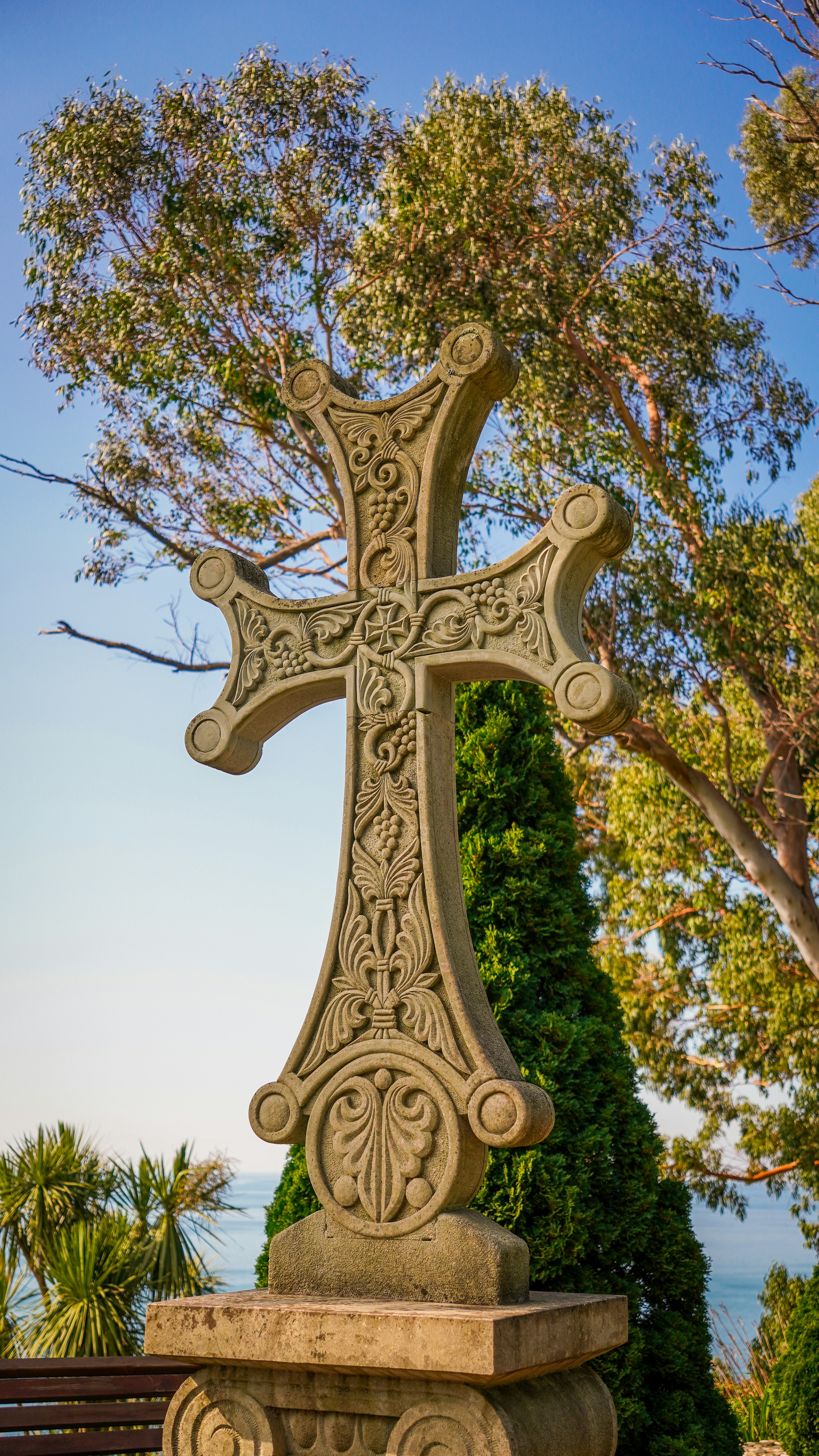 Stone Crossway: Intricate Carving Rising Above Coastal Landscape